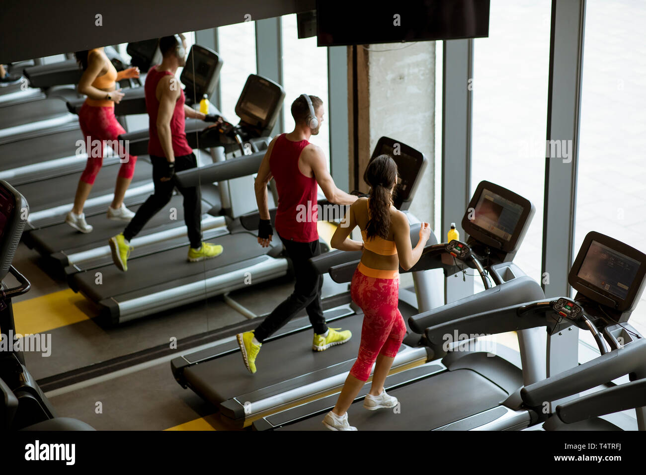 Man and woman doing cardio workout on treadmills in fitness club Stock ...