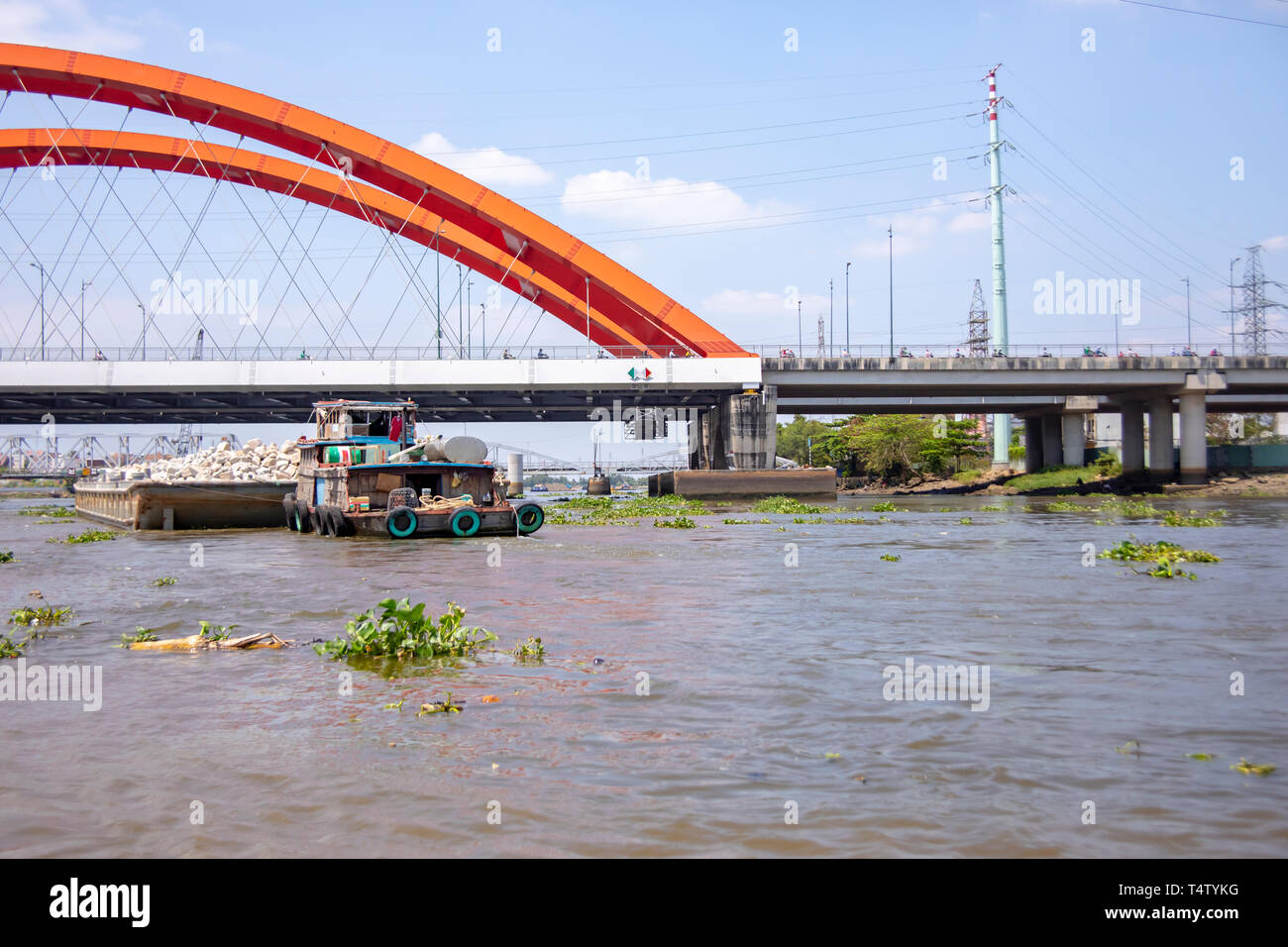 Barge hauling boulders under bridge on Saigon River, Vietnam Stock ...