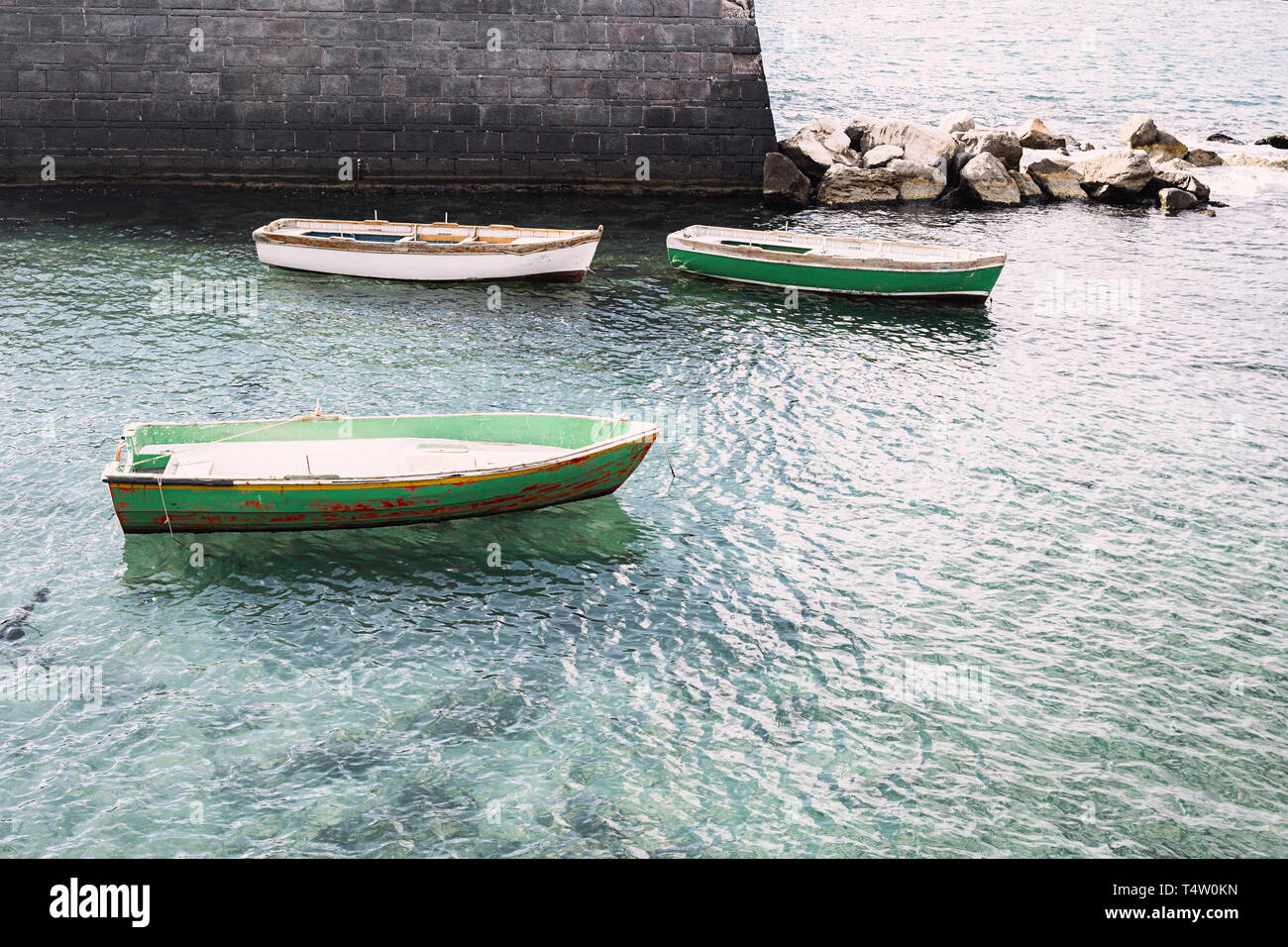 Old fishing boats floating on the water. Nobody around. Small row boats ...