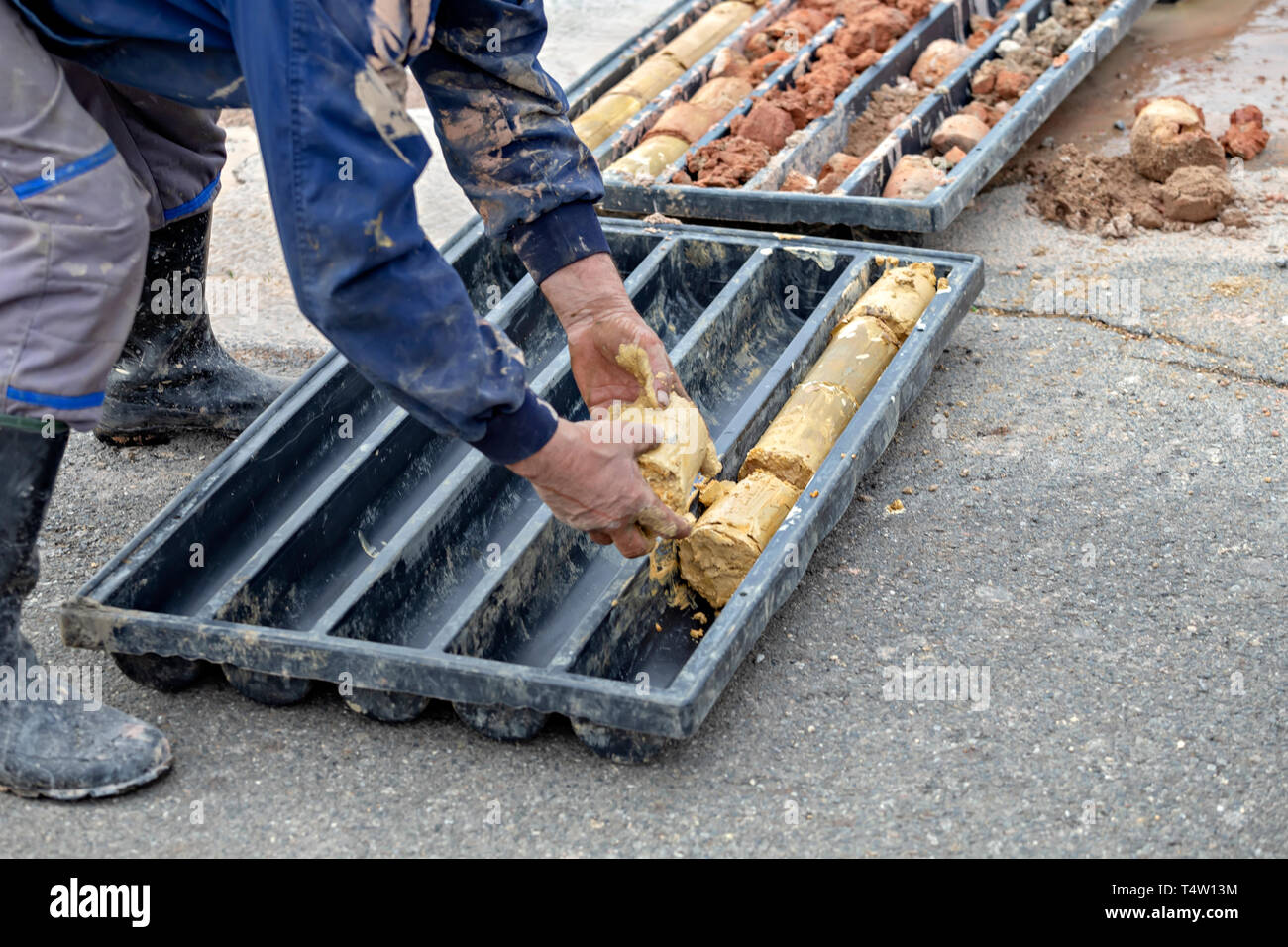 Driller obtaining soil samples in plastic box. Soil boring and soil ...