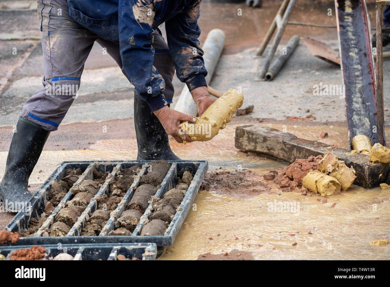 Driller obtaining soil samples in plastic core box. Soil boring and ...