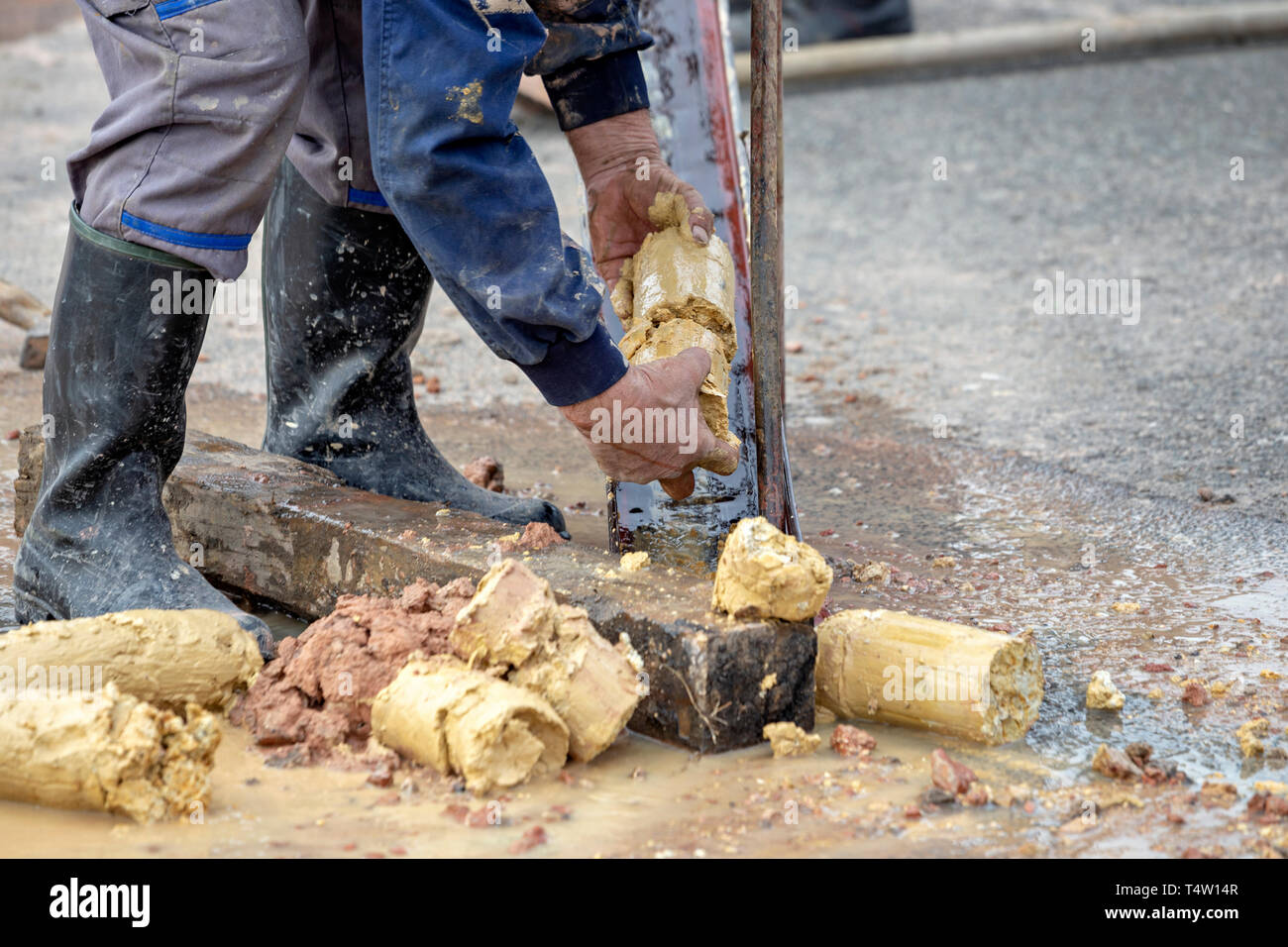 Driller obtaining soil samples in plastic core box. Soil boring and ...