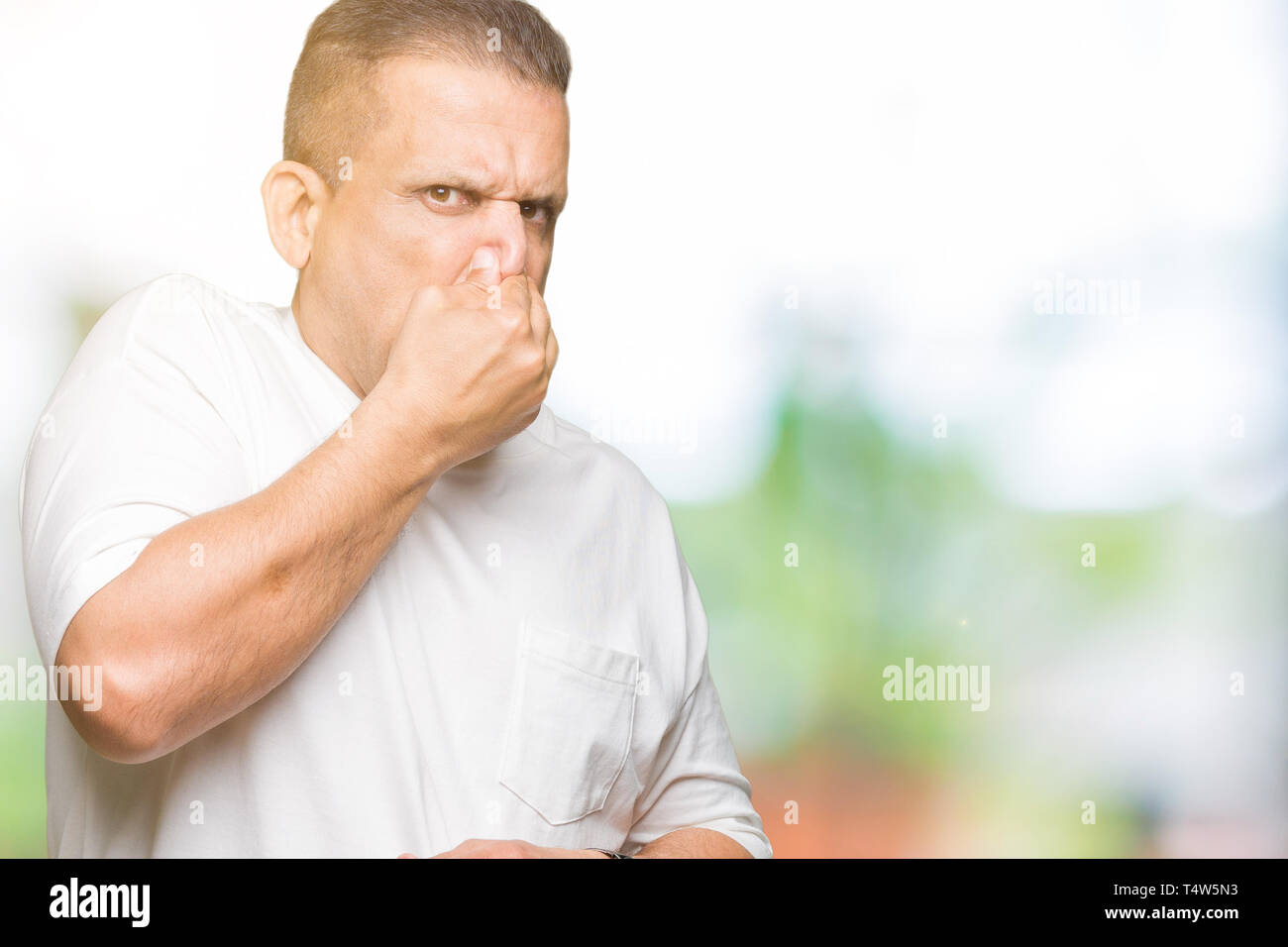 Middle age arab man wearig white t-shirt over isolated background ...