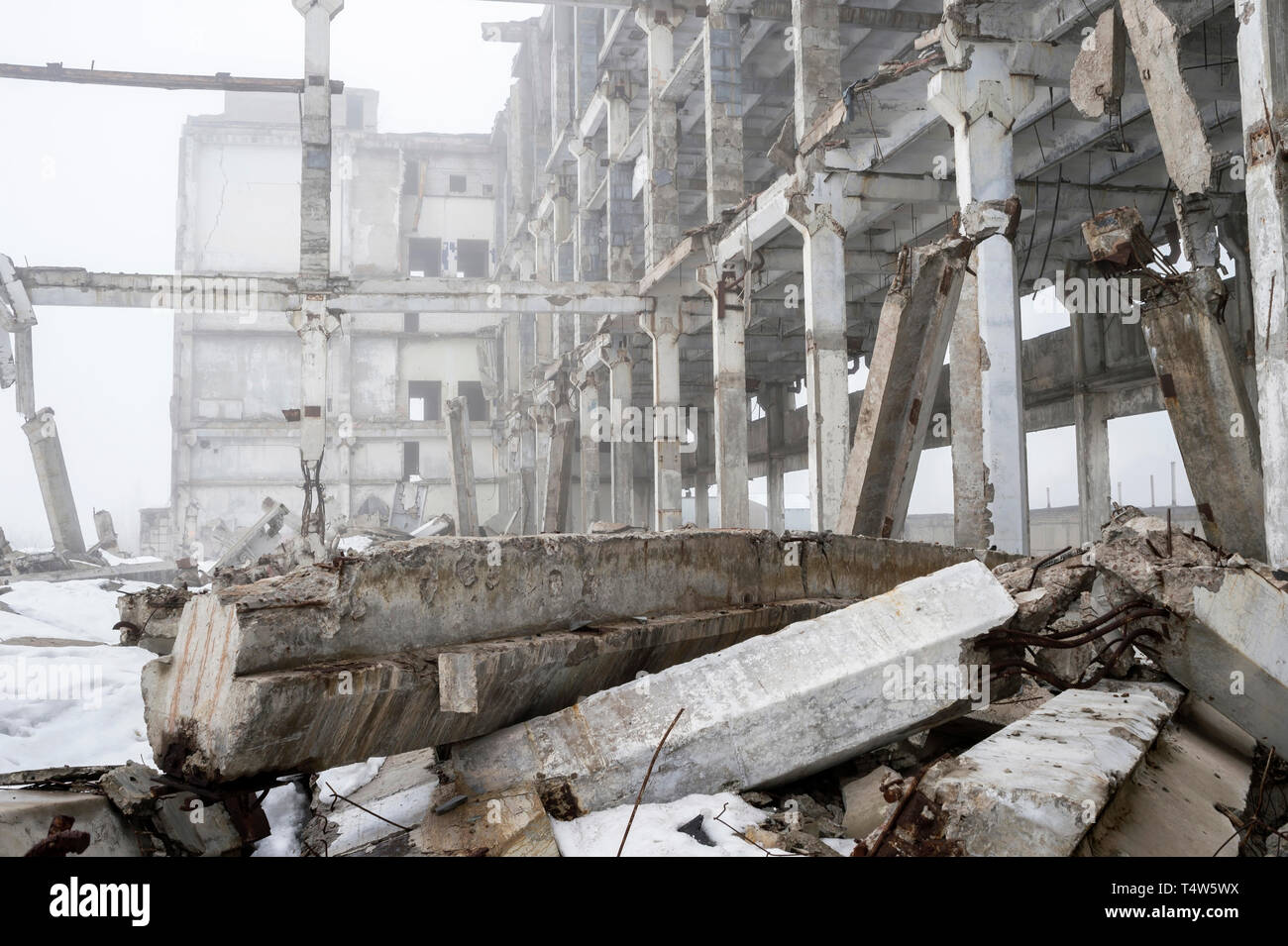 Destroyed large concrete building in a foggy haze with the remains of ...