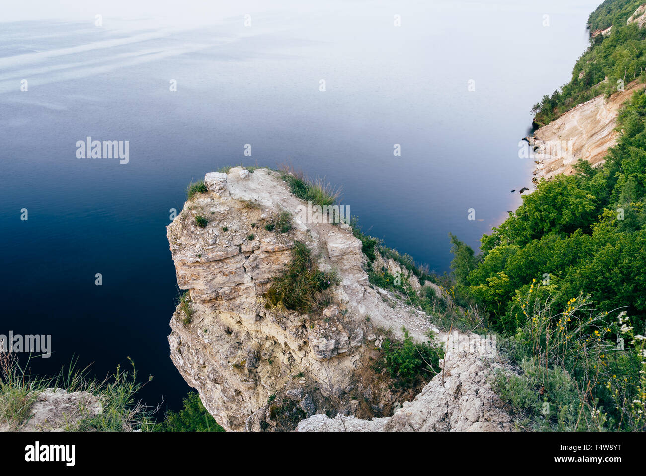Edge of cliff with grass and flowers Stock Photo - Alamy