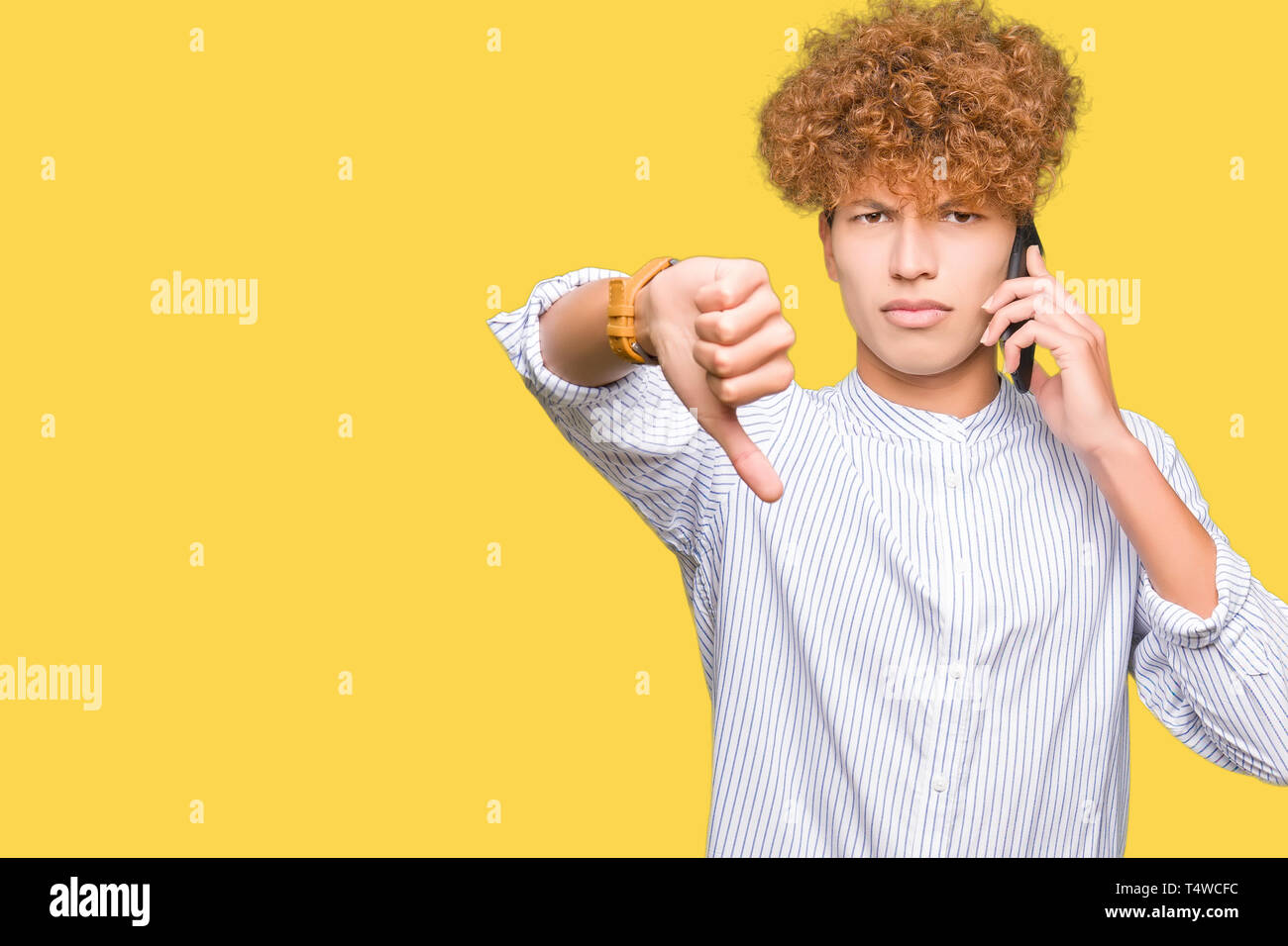 Young handsome man talking on the phone with angry face, negative sign ...