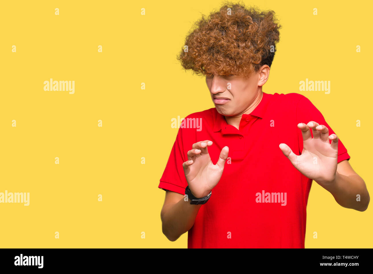 Young handsome man with afro hair wearing red t-shirt disgusted ...