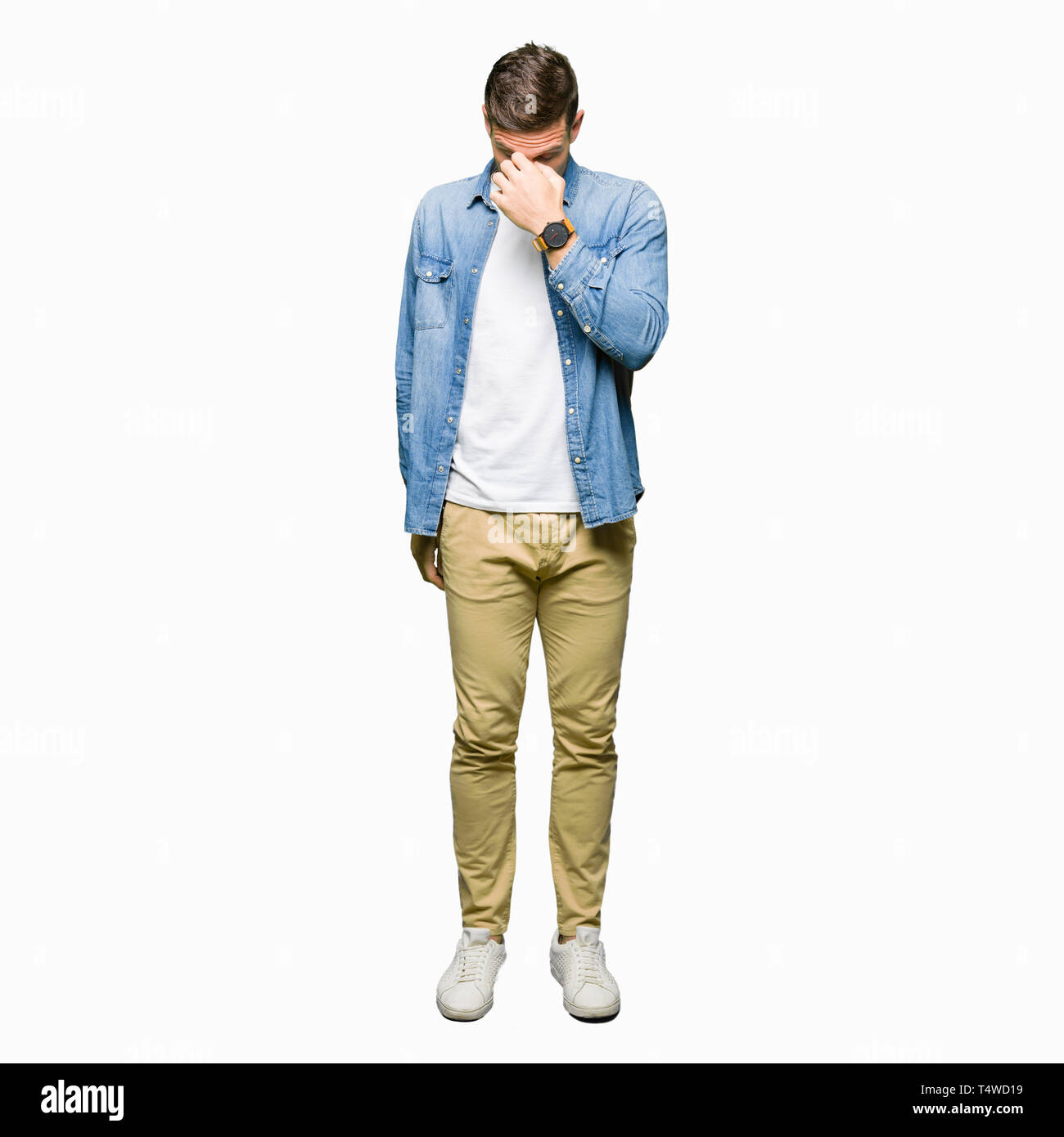 Handsome man with blue eyes and beard wearing denim jacket tired ...