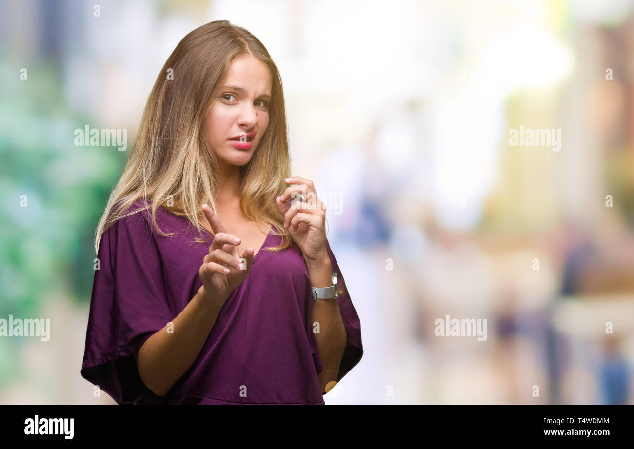 Young beautiful blonde elegant woman over isolated background disgusted ...