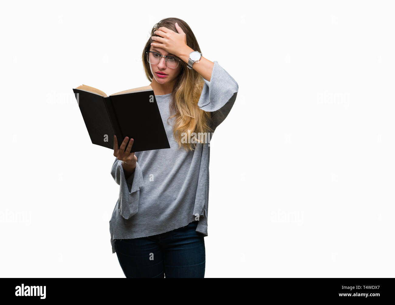 Young beautiful blonde woman reading a book over isolated background ...
