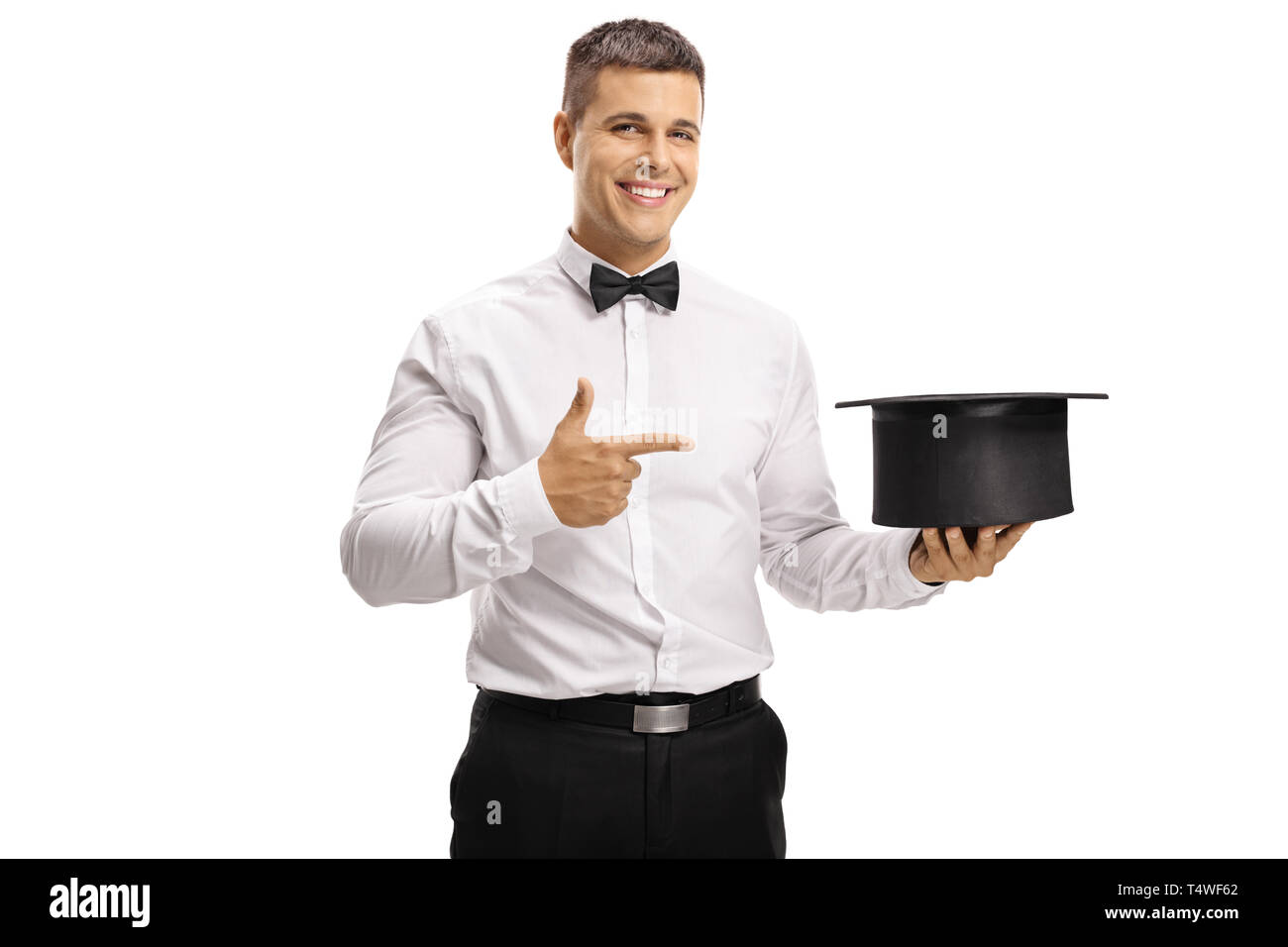 Young magician holding an empty hat and pointing isolated on white ...