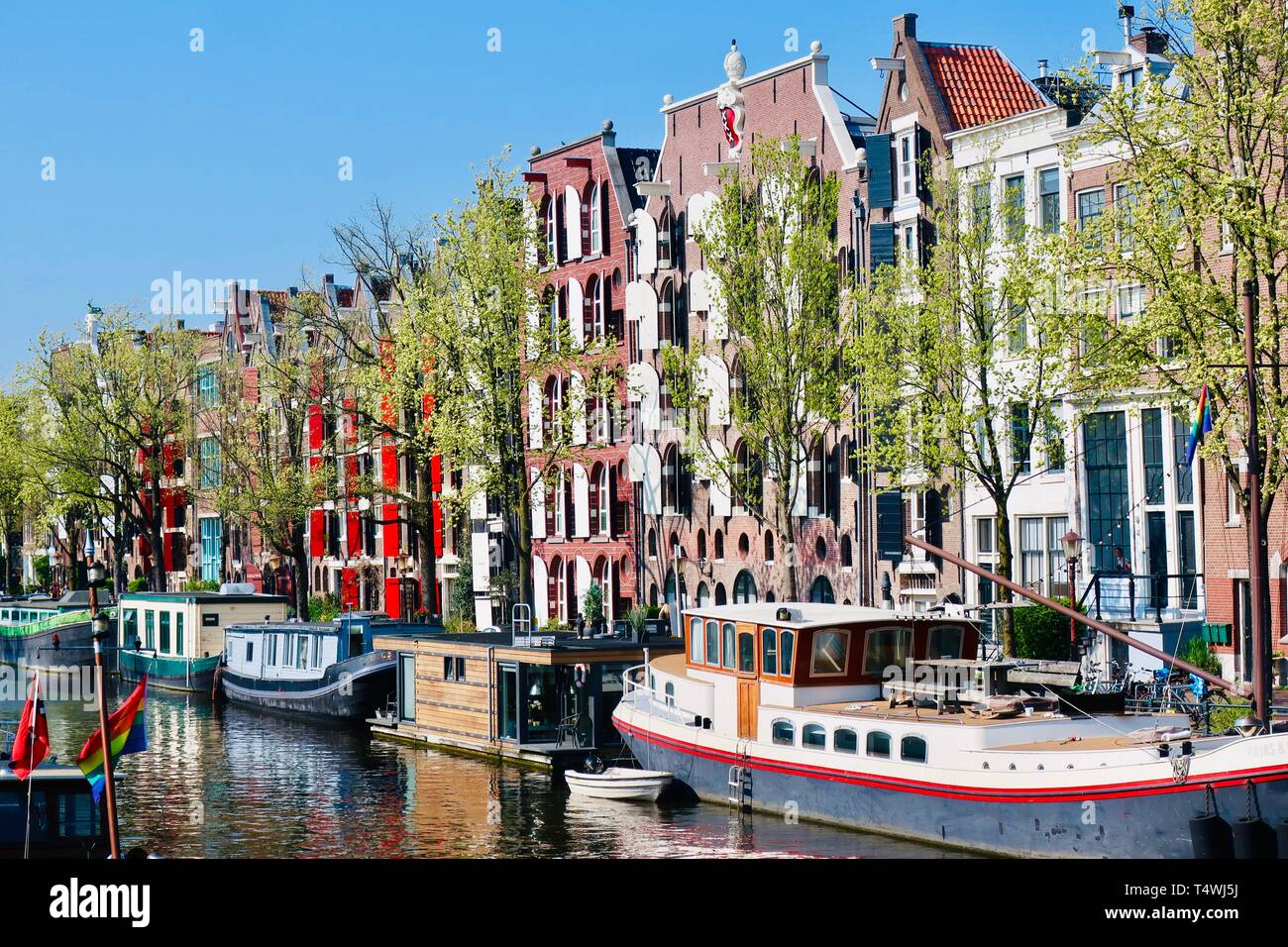 Amsterdam, Netherlands - April 2019: Typical colourful Dutch tall canal ...