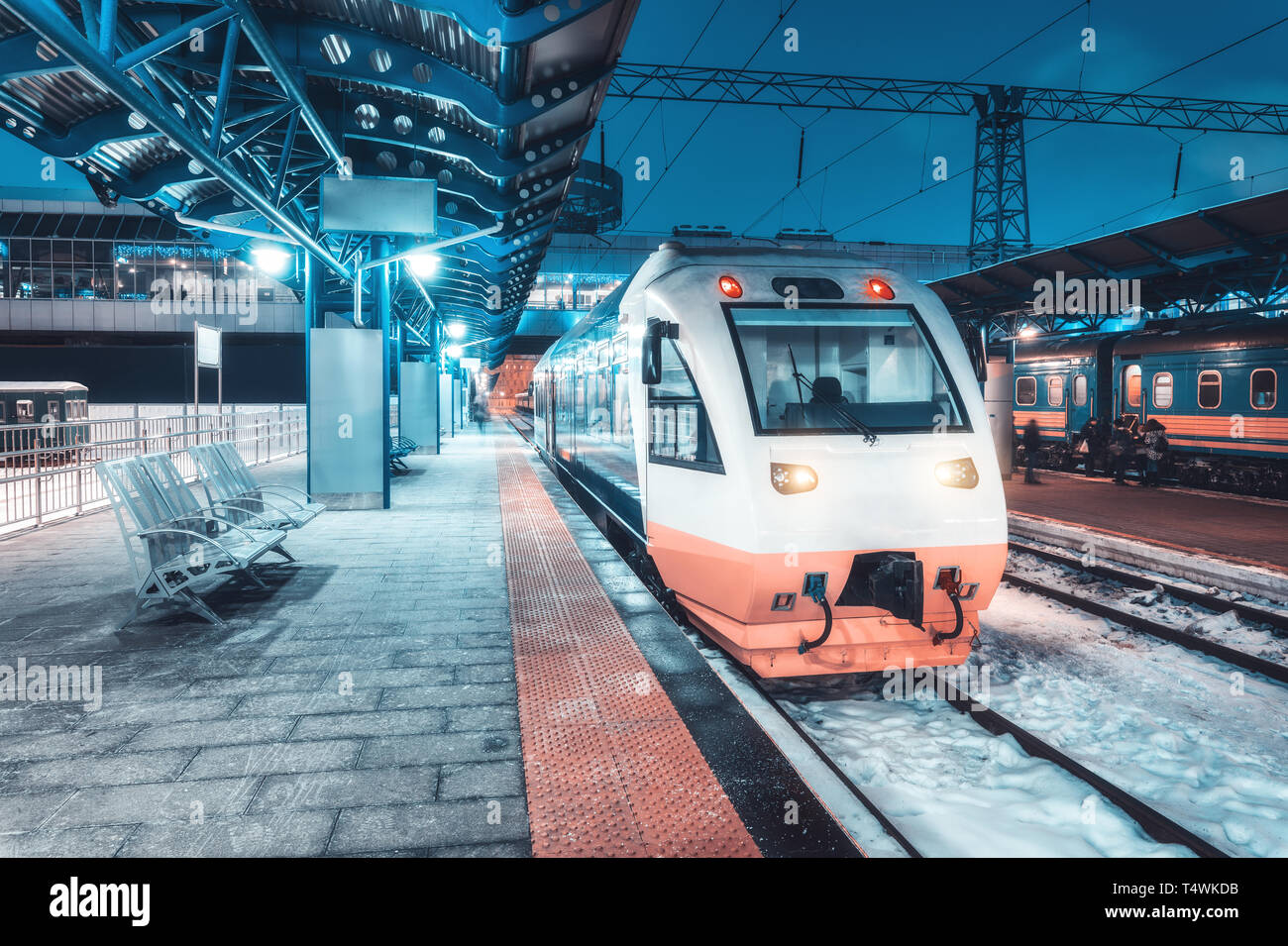 High speed train on the railway station at night in winter. Urban ...
