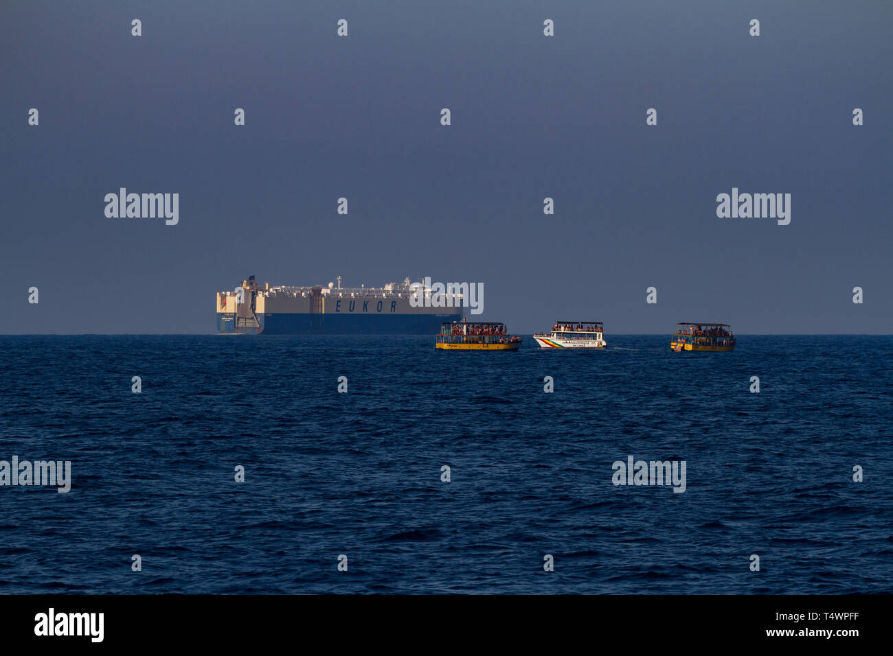 Whale watching boats with large container ship in background. Near ...