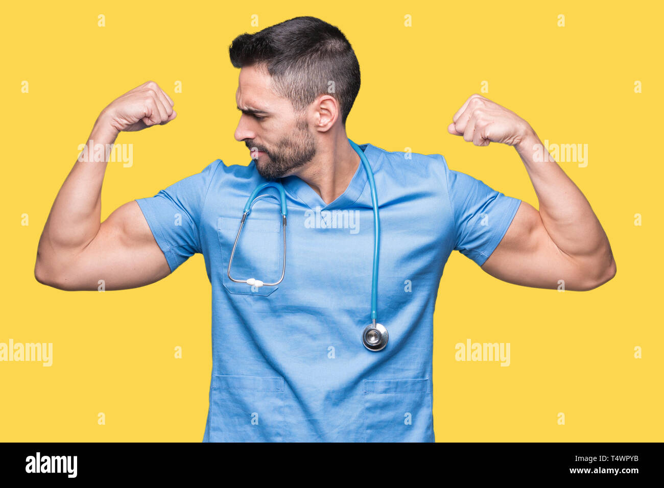 Handsome young doctor surgeon man over isolated background showing arms ...