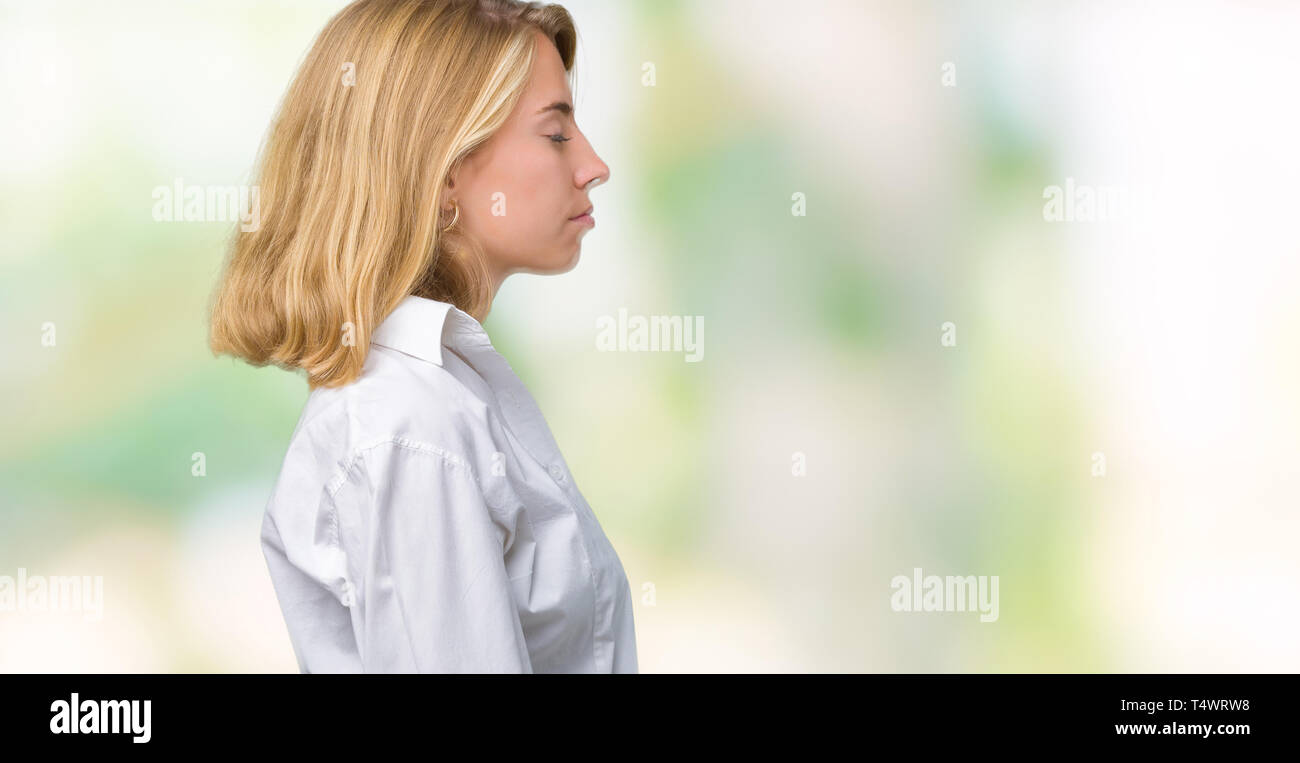 Beautiful young business woman over isolated background looking to side ...