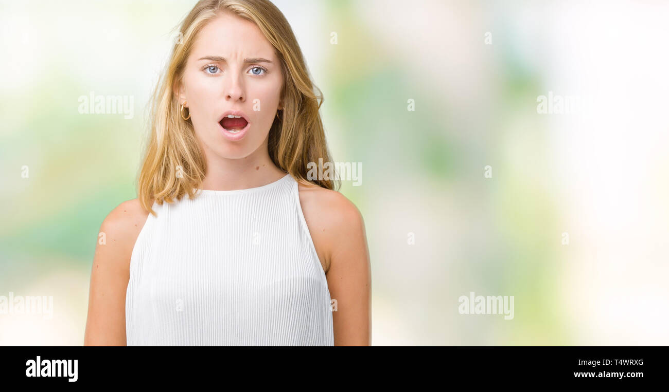 Beautiful young elegant woman over isolated background In shock face ...