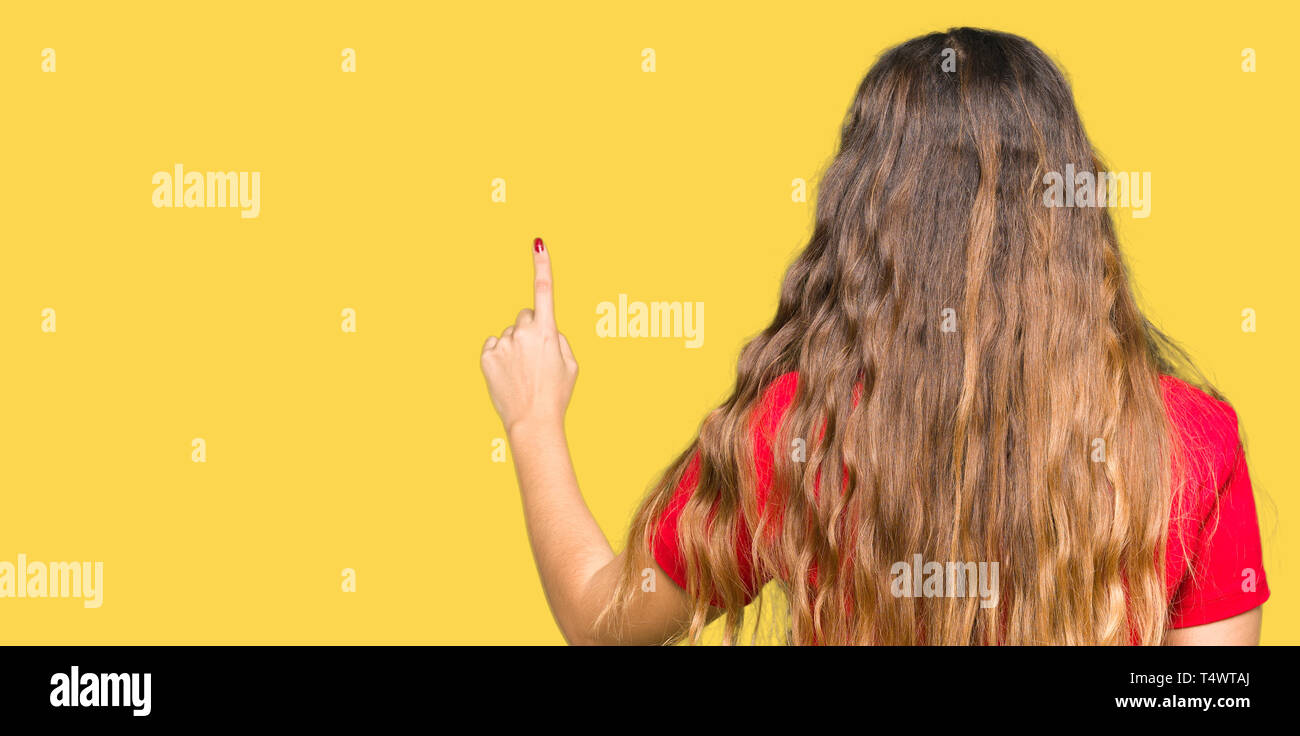 Young beautiful woman wearing casual t-shirt Posing backwards pointing ...