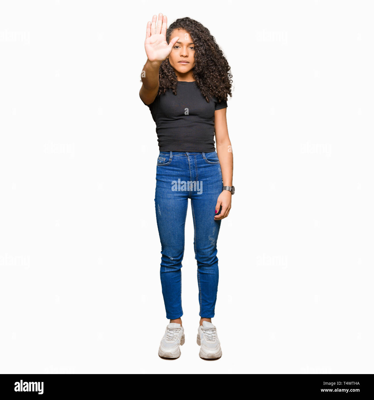 Young beautiful woman with curly hair doing stop sing with palm of the ...