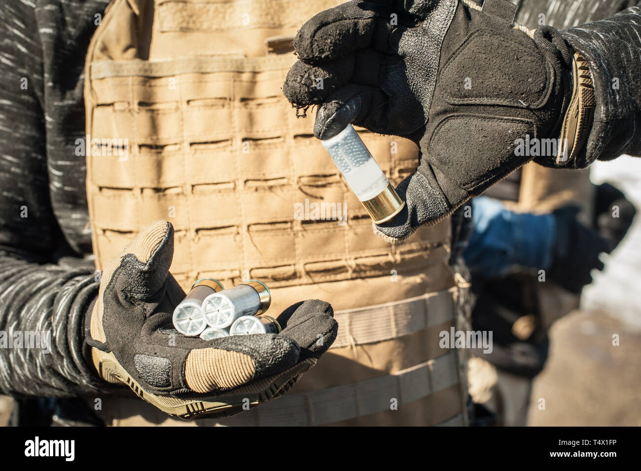 Close-up top macro detail view of army soldier hands holding shotgun ...