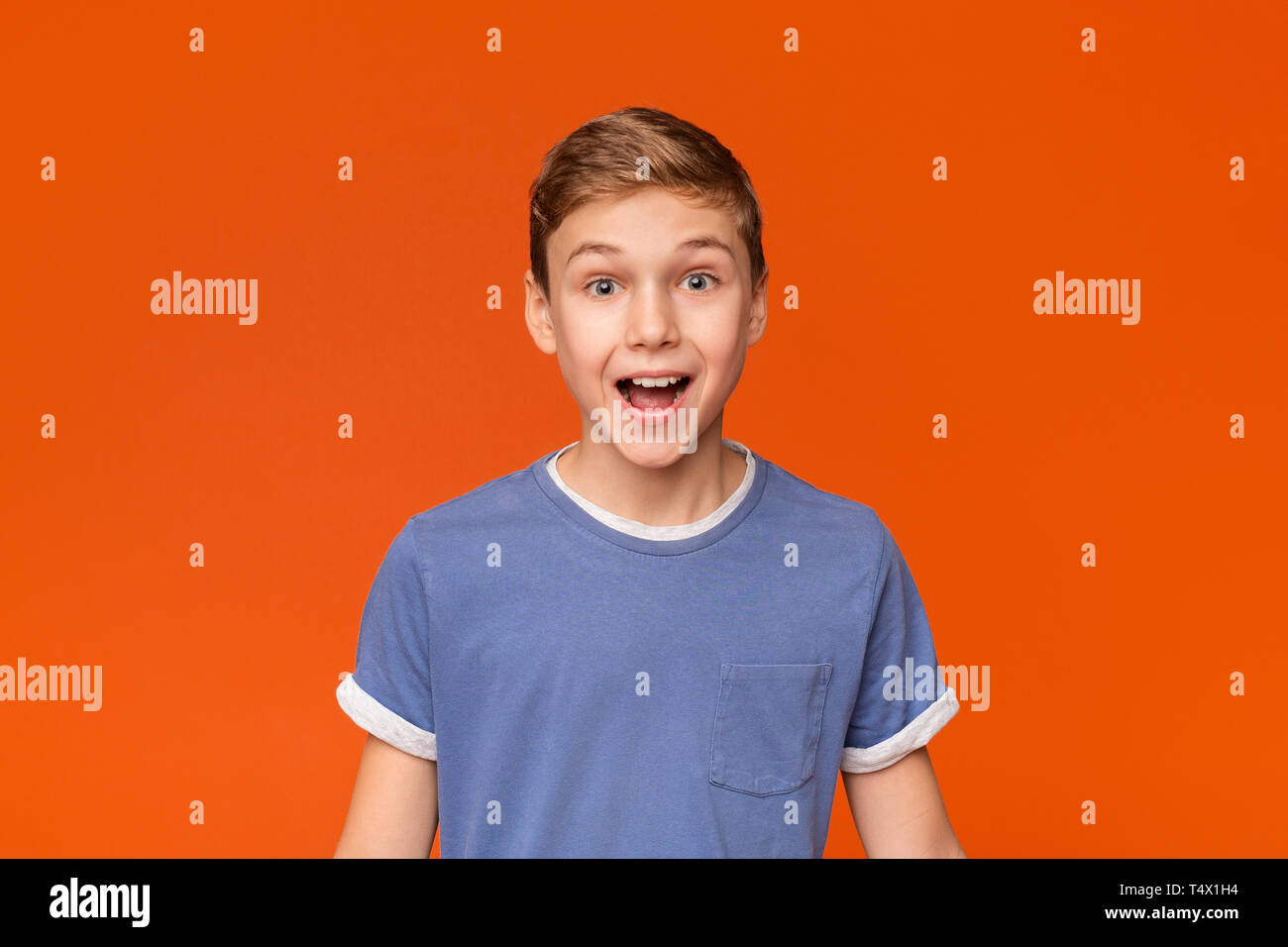 Shocked kid keeping mouth open and touching face Stock Photo - Alamy