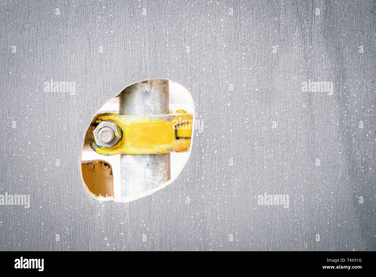 Light gray wall background. Part of pipe with nut. Scaffolding, detail ...