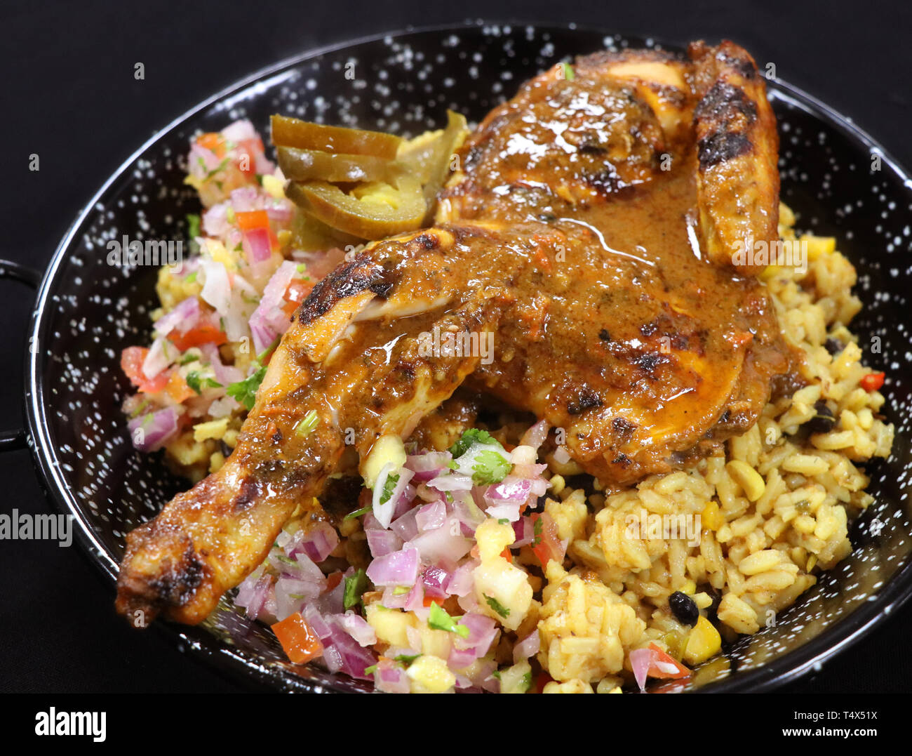 spice roasted whole baby chicken with flavored rice in a serving dish ...