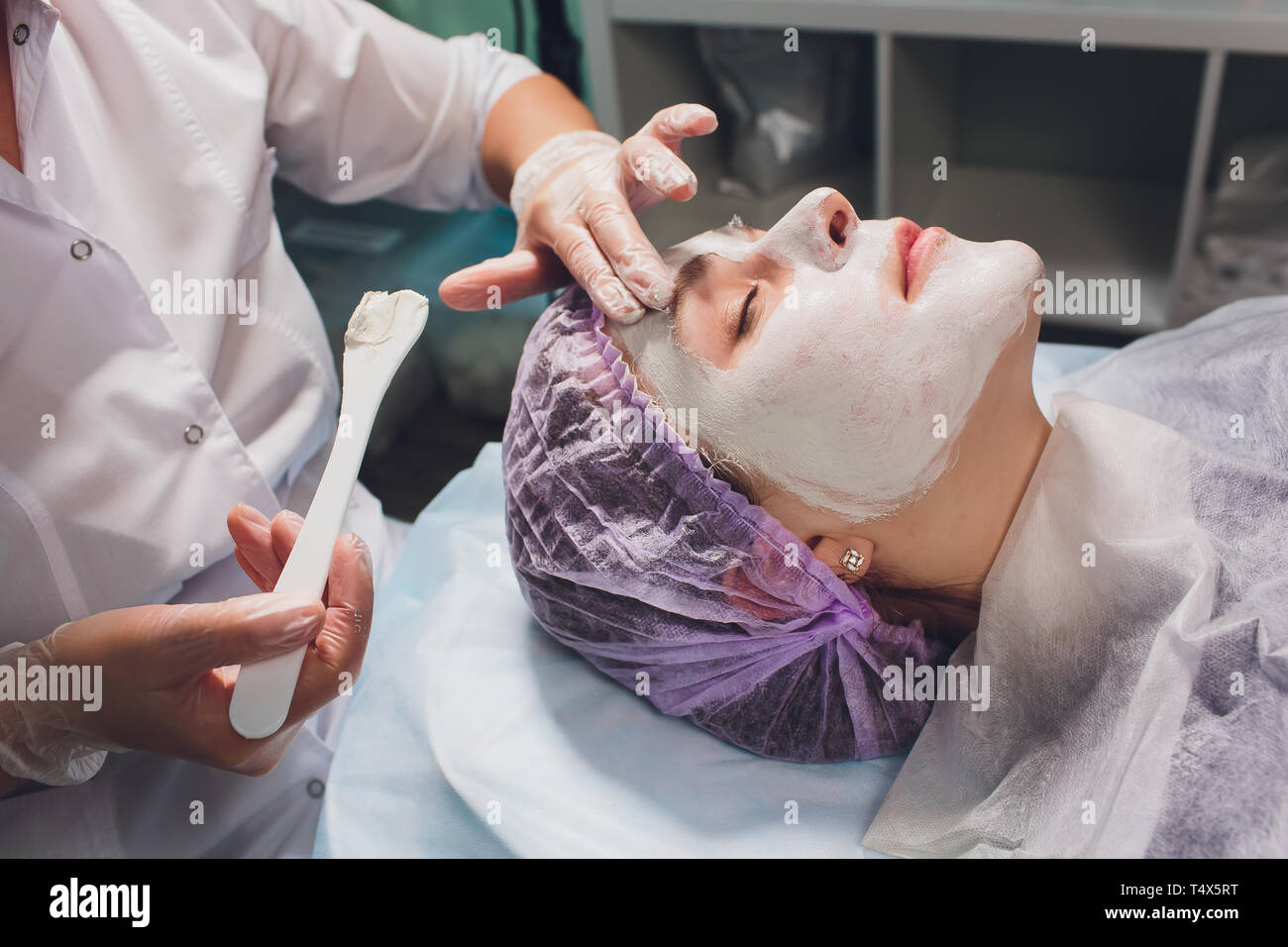 Beautiful european woman having facial skin procedure by applying a ...