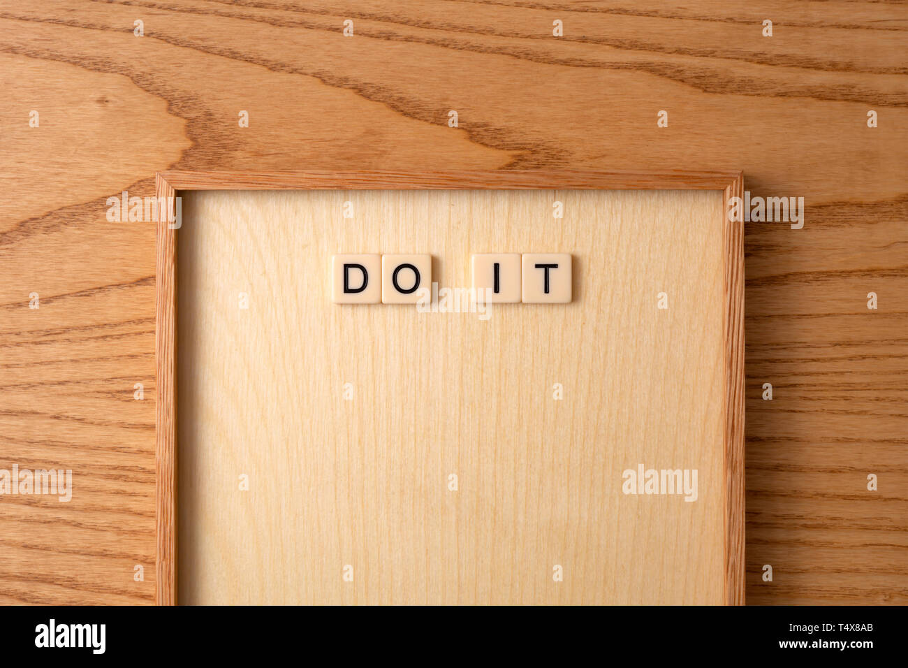 DO IT word block on wood background Stock Photo - Alamy