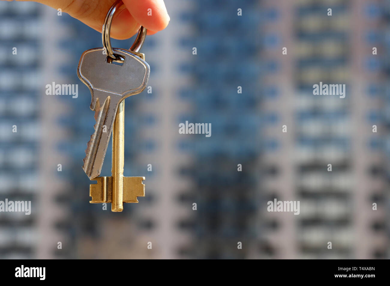Apartment purchase, real estate agent holding house key on background ...
