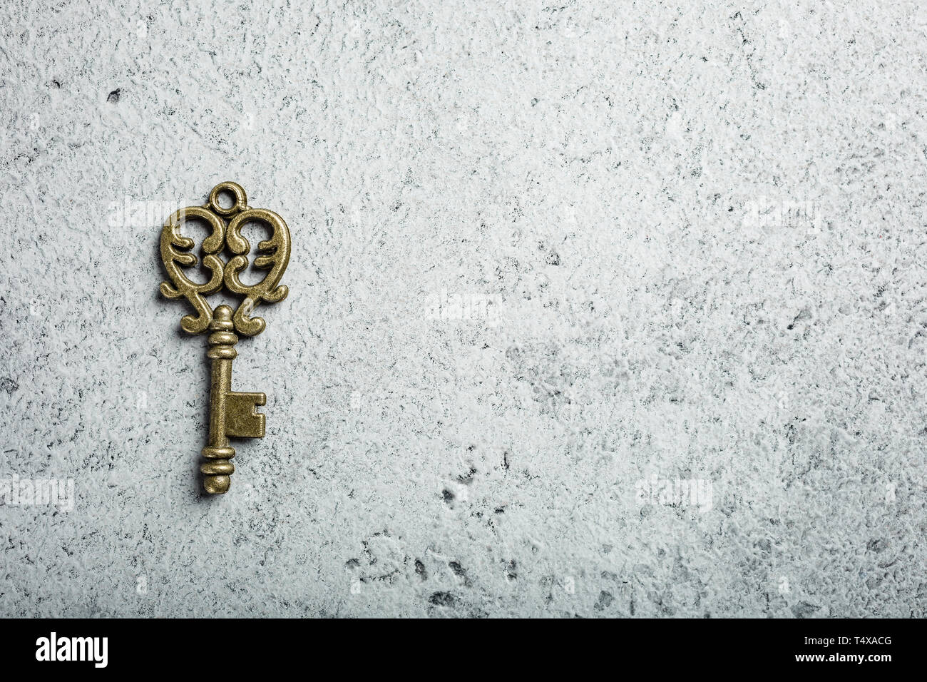 Old key on old gray concrete background Stock Photo - Alamy
