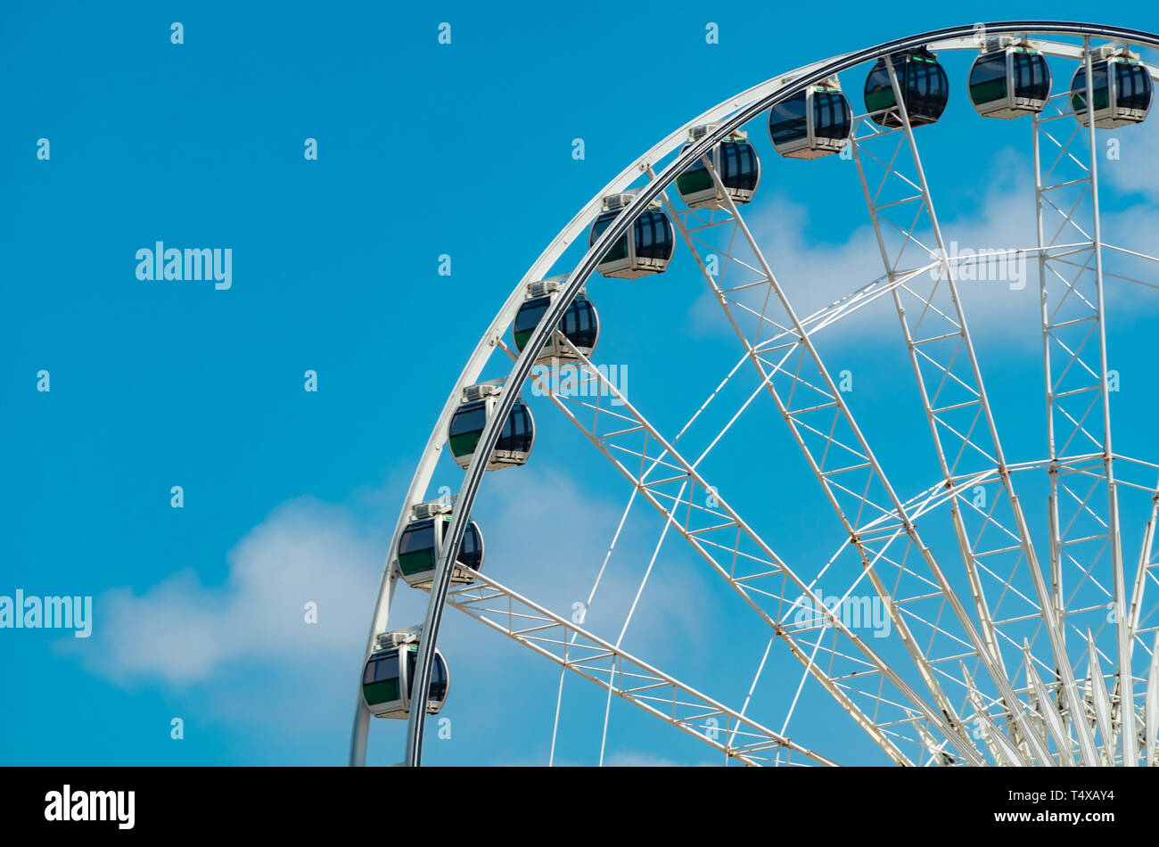 Closeup modern Ferris wheel against blue sky and white clouds. Ferris ...