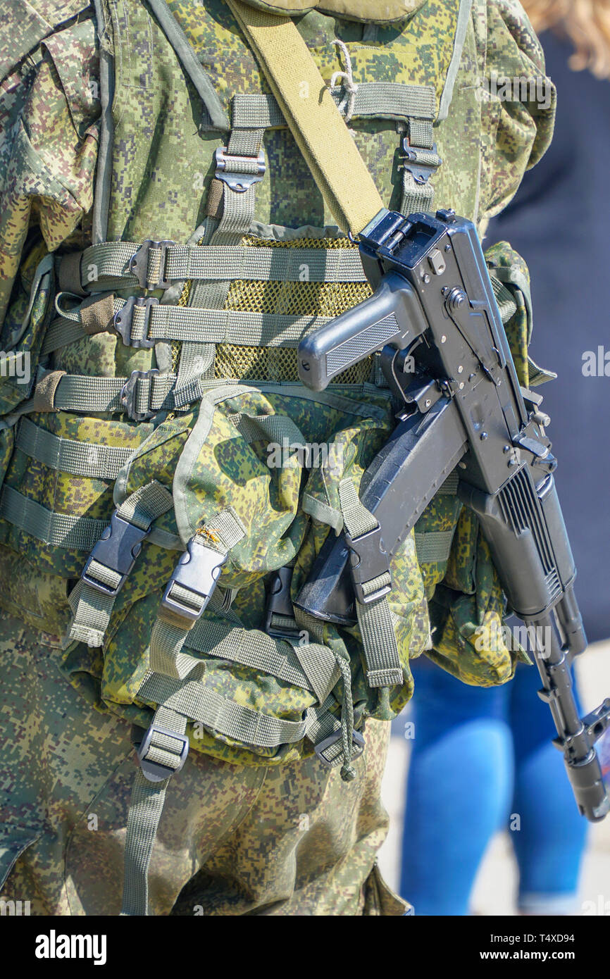 Soldier in camouflage with a gun behind his back Stock Photo - Alamy