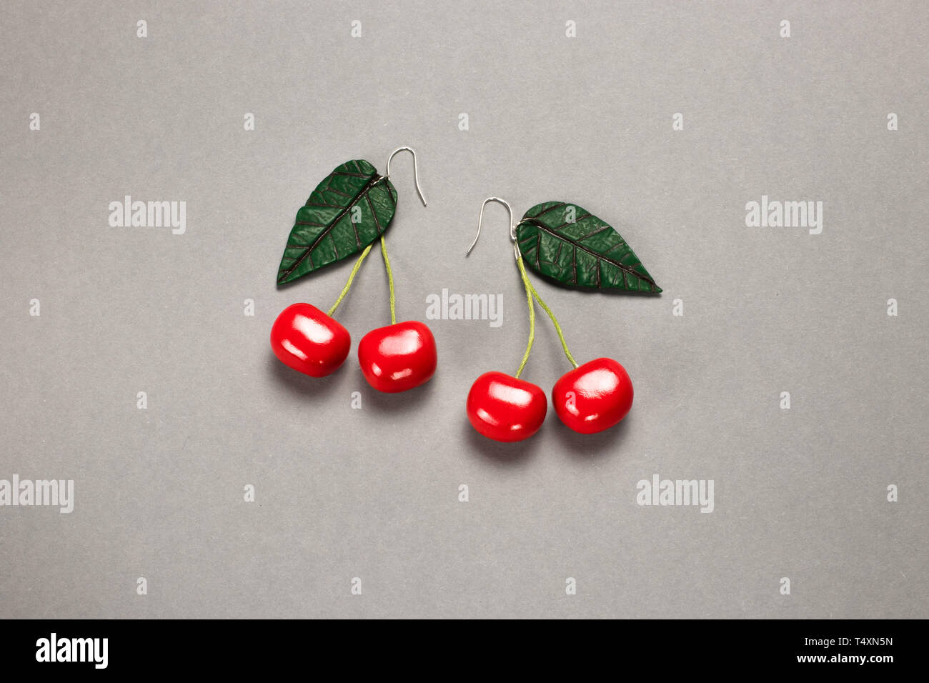 Hand made custom cherry polymer clay earrings on grey fabric background ...
