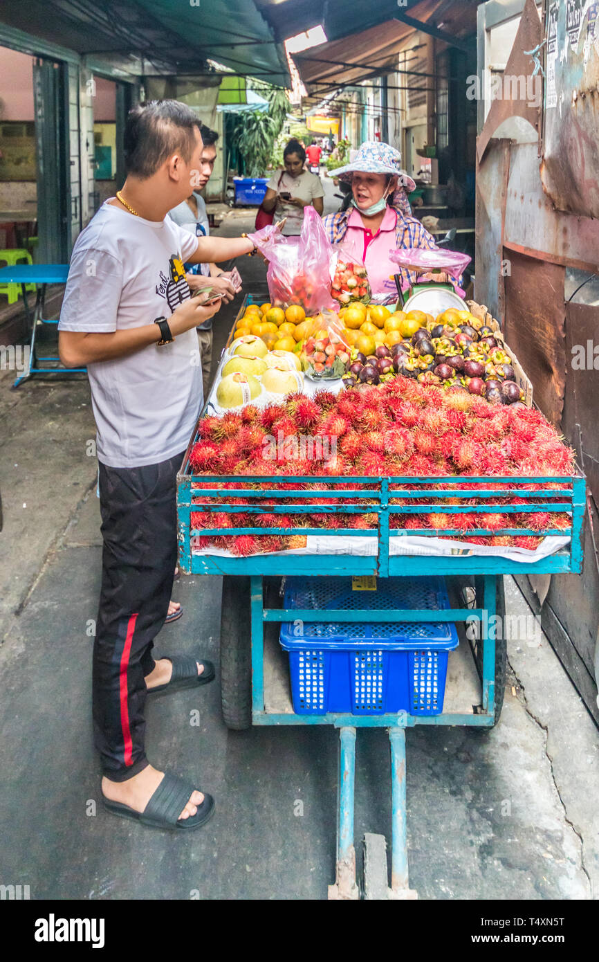Bangkok, Thailand - January 31st 2019: Fruit vendor with customer in a ...