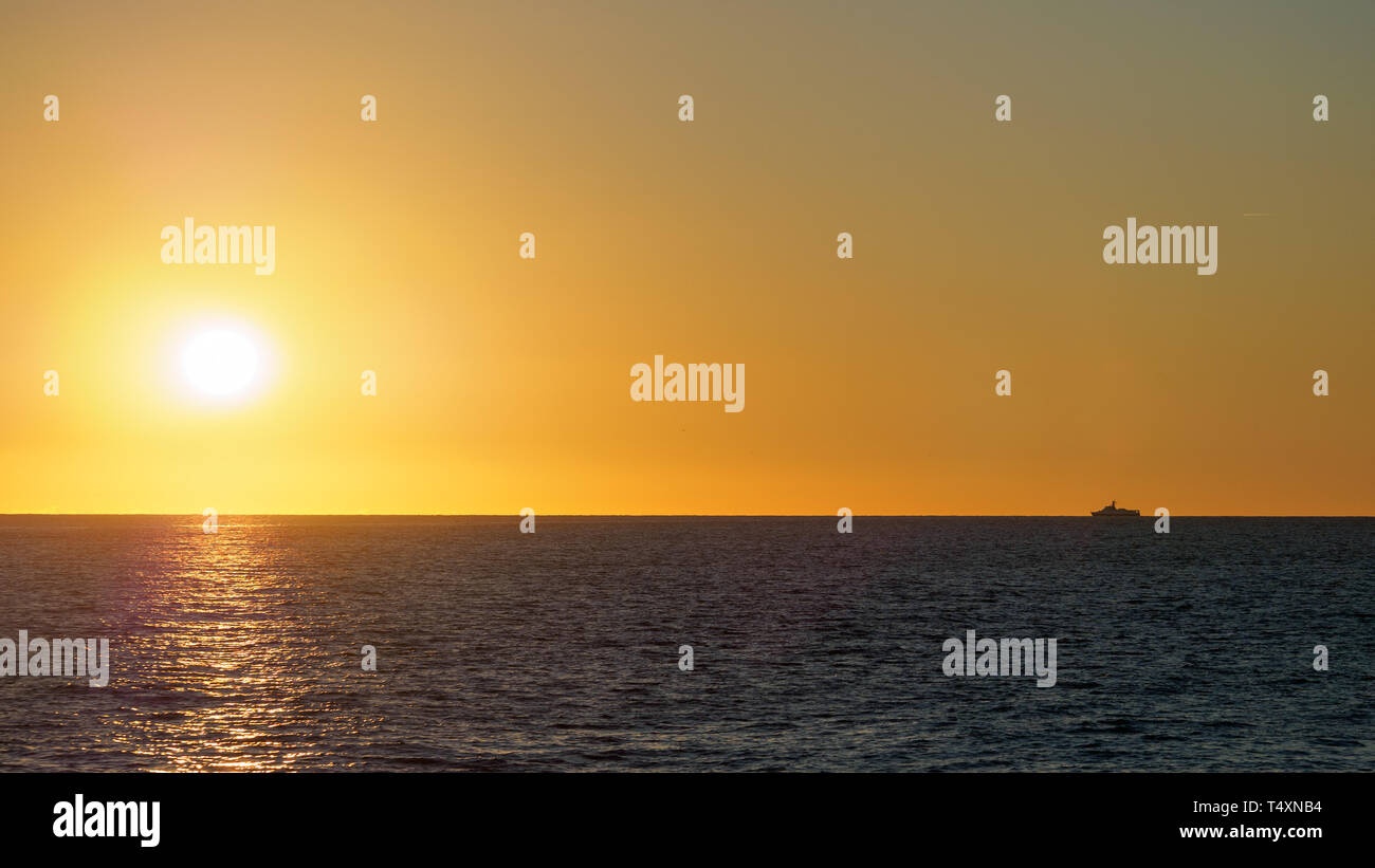 Orange sunset over the sea. Lonely ship on the horizon Stock Photo - Alamy
