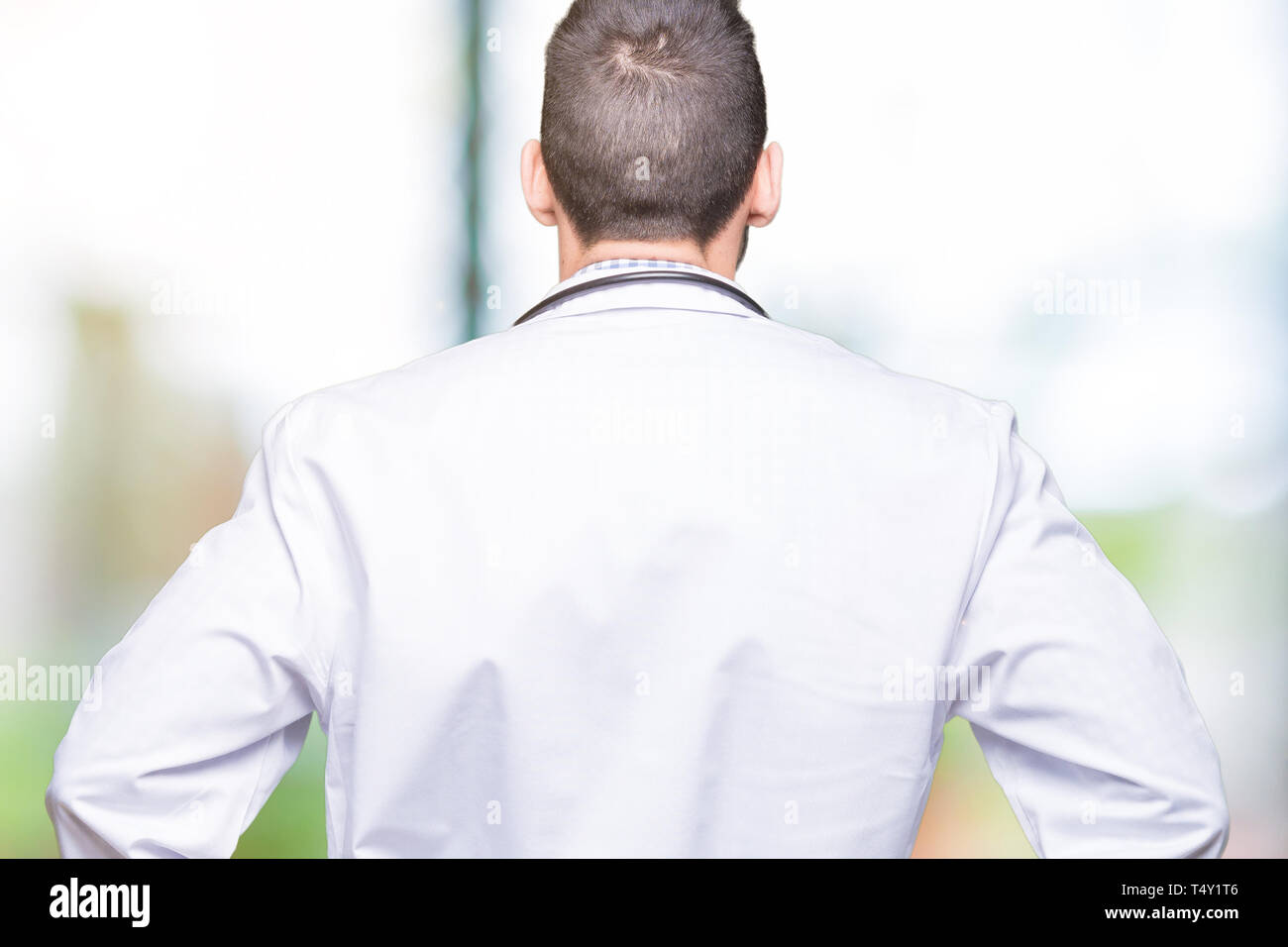 Handsome young doctor man over isolated background standing backwards ...