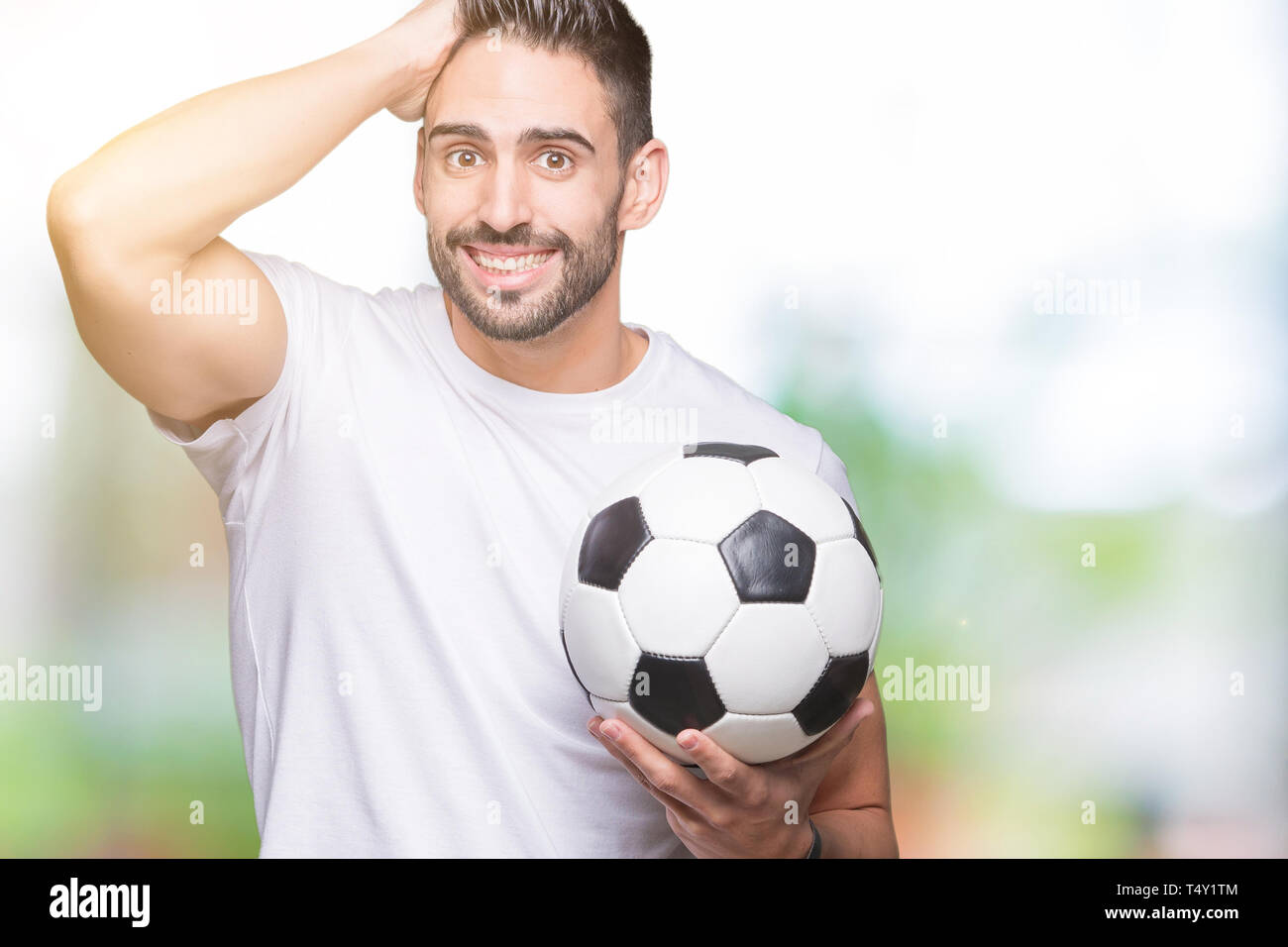 Young man holding soccer football ball over isolated background ...