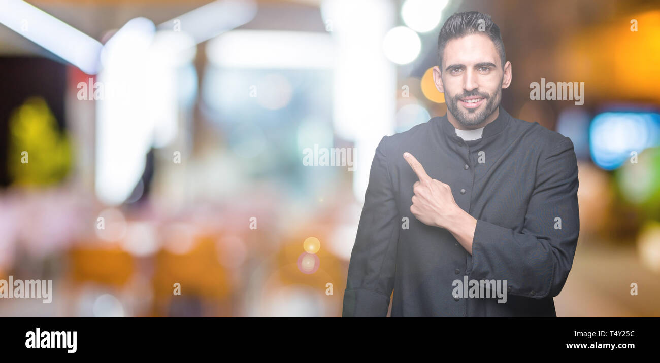 Young Christian priest over isolated background Pointing with hand ...
