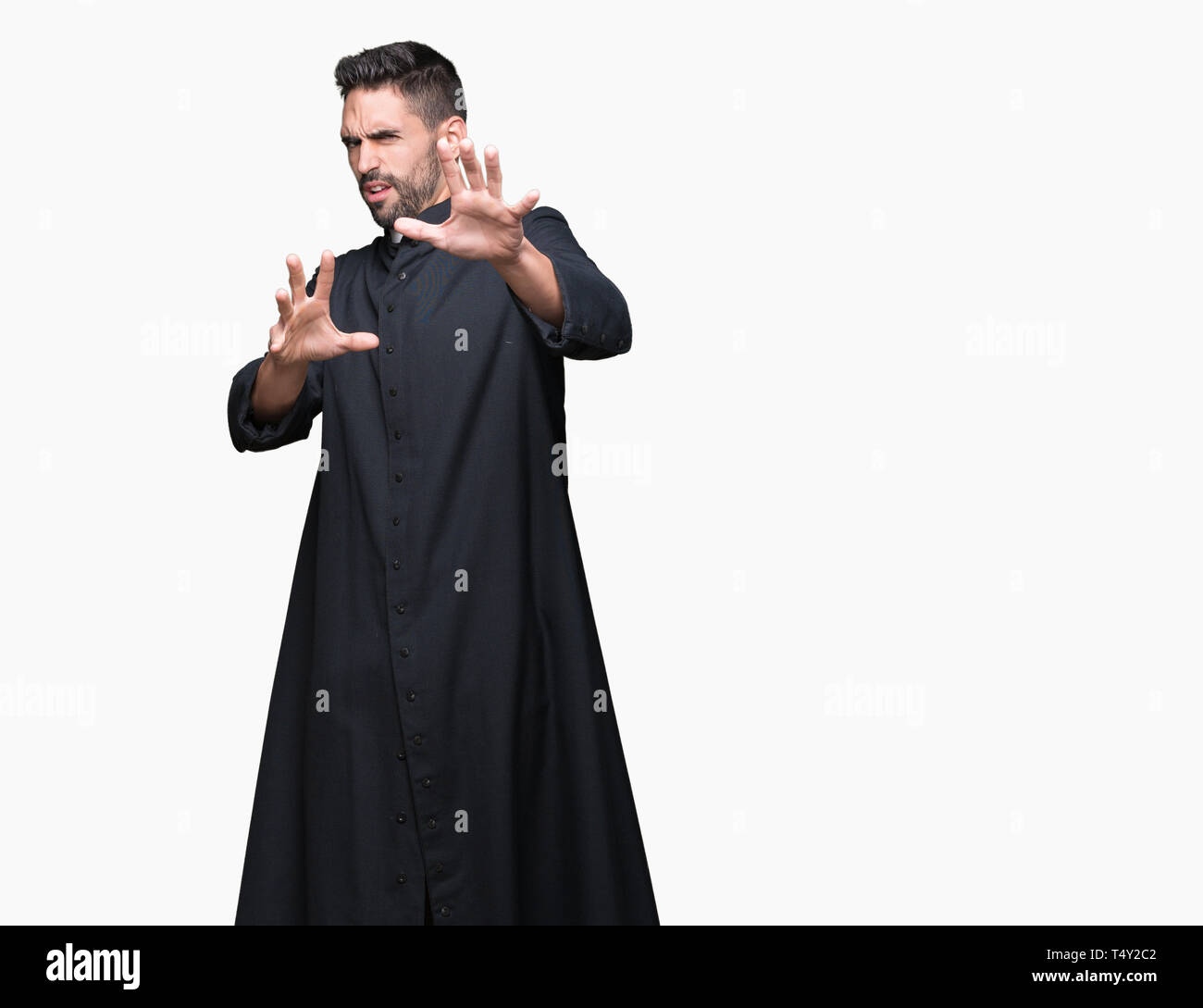 Young Christian priest over isolated background afraid and terrified ...