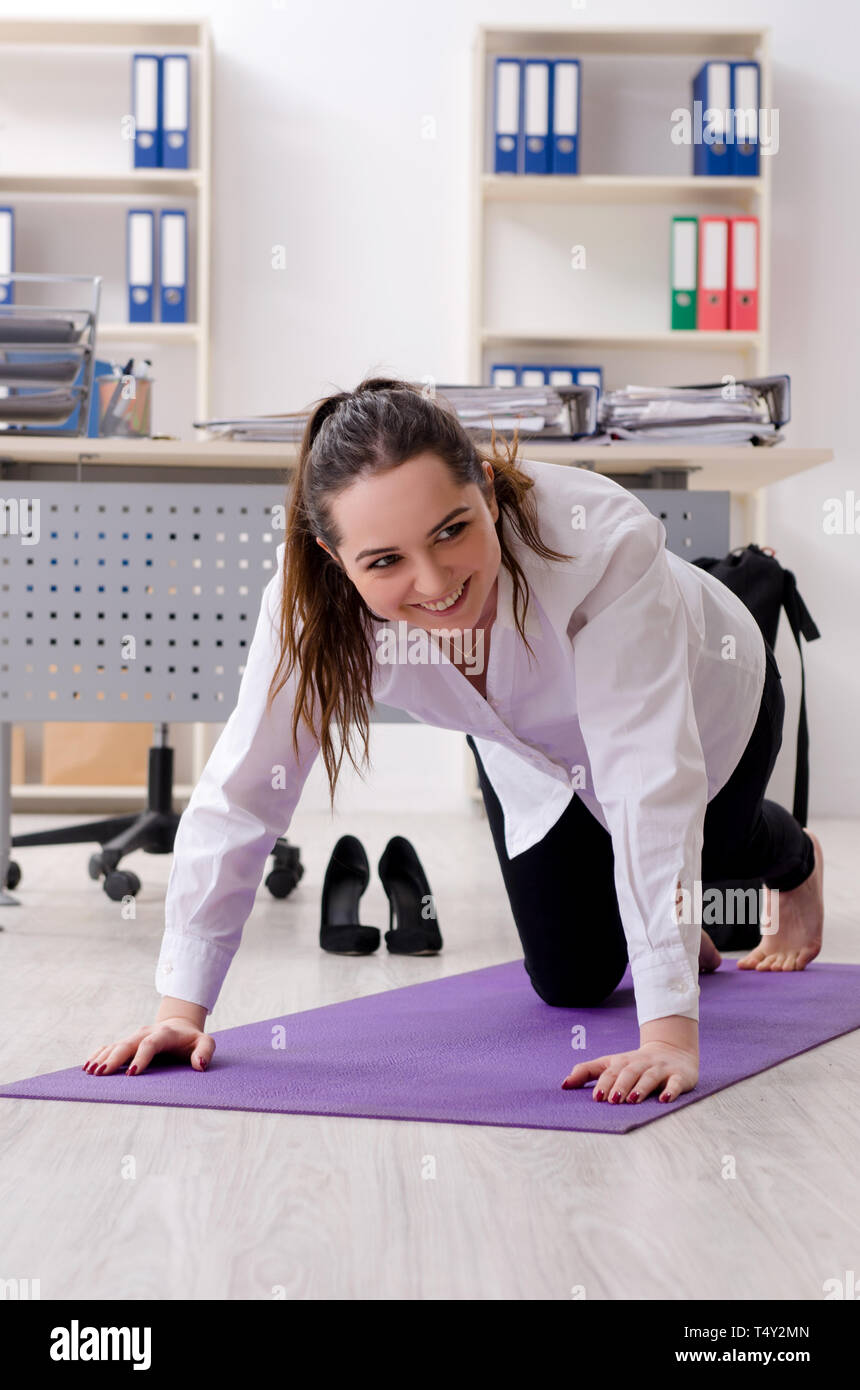 Female employee doing sport exercises in the office Stock Photo - Alamy