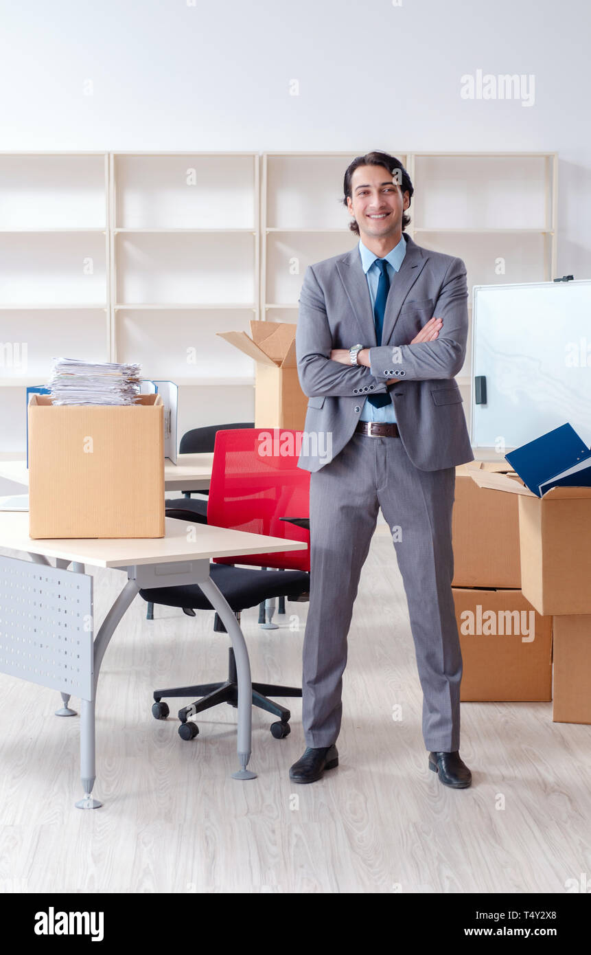Young man employee with boxes in the office Stock Photo - Alamy