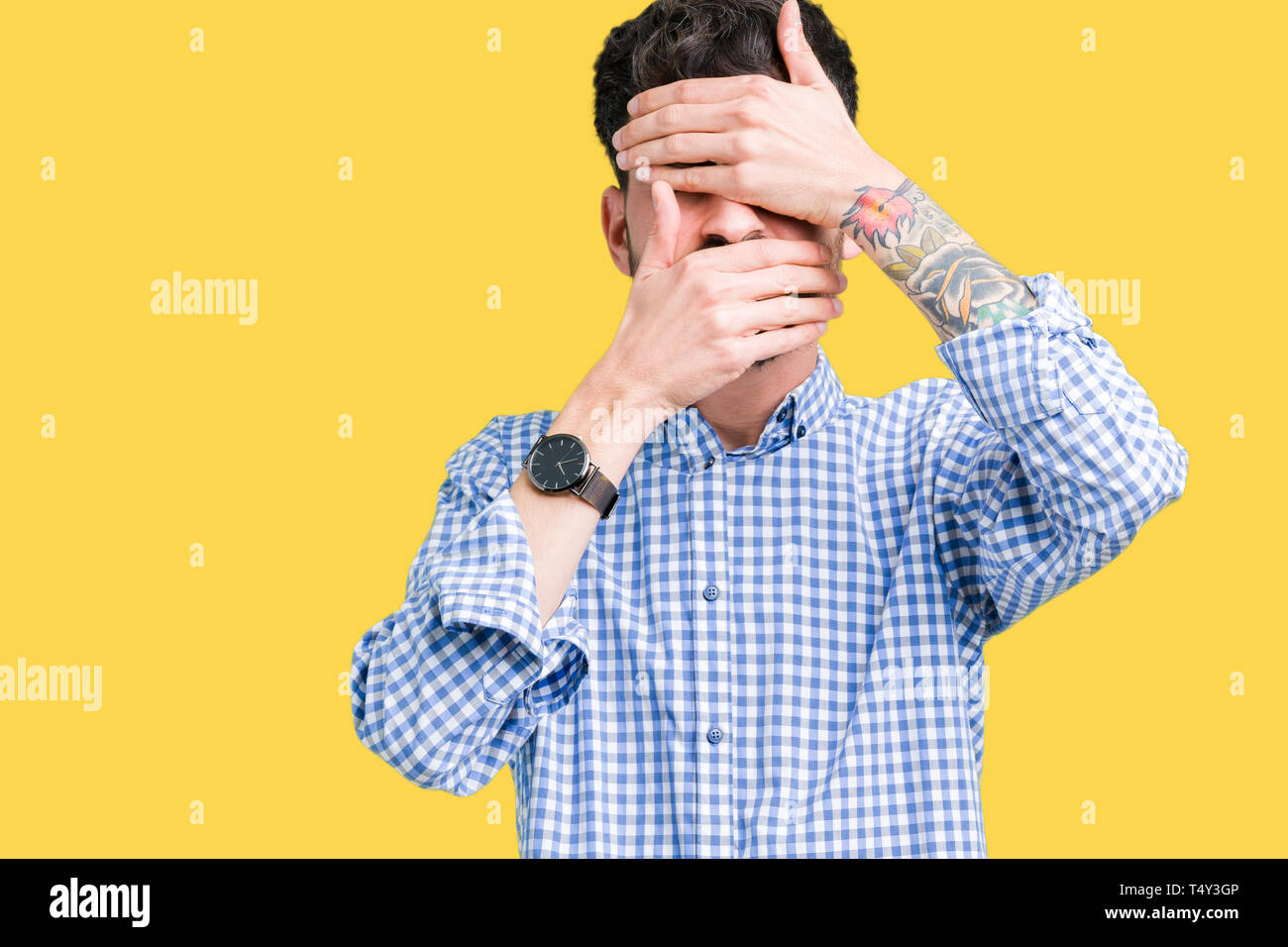 Young handsome business man over isolated background Covering eyes and mouth with hands ...
