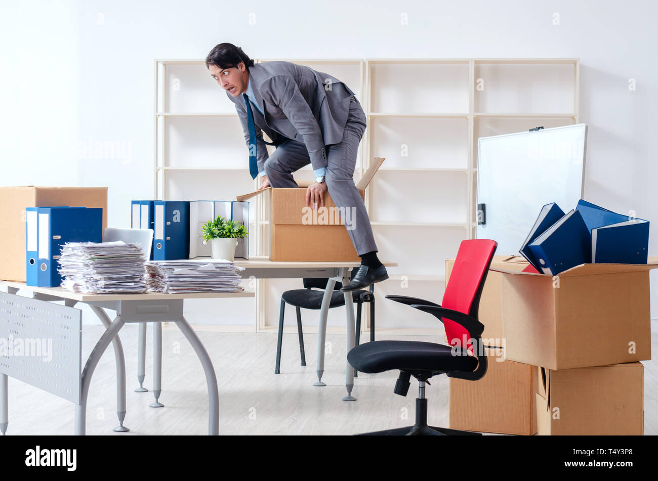 Young man employee with boxes in the office Stock Photo - Alamy