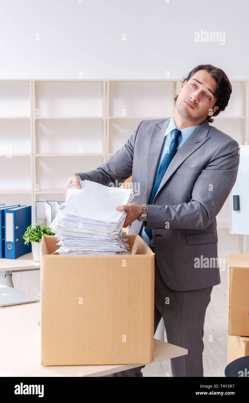 Young man employee with boxes in the office Stock Photo - Alamy
