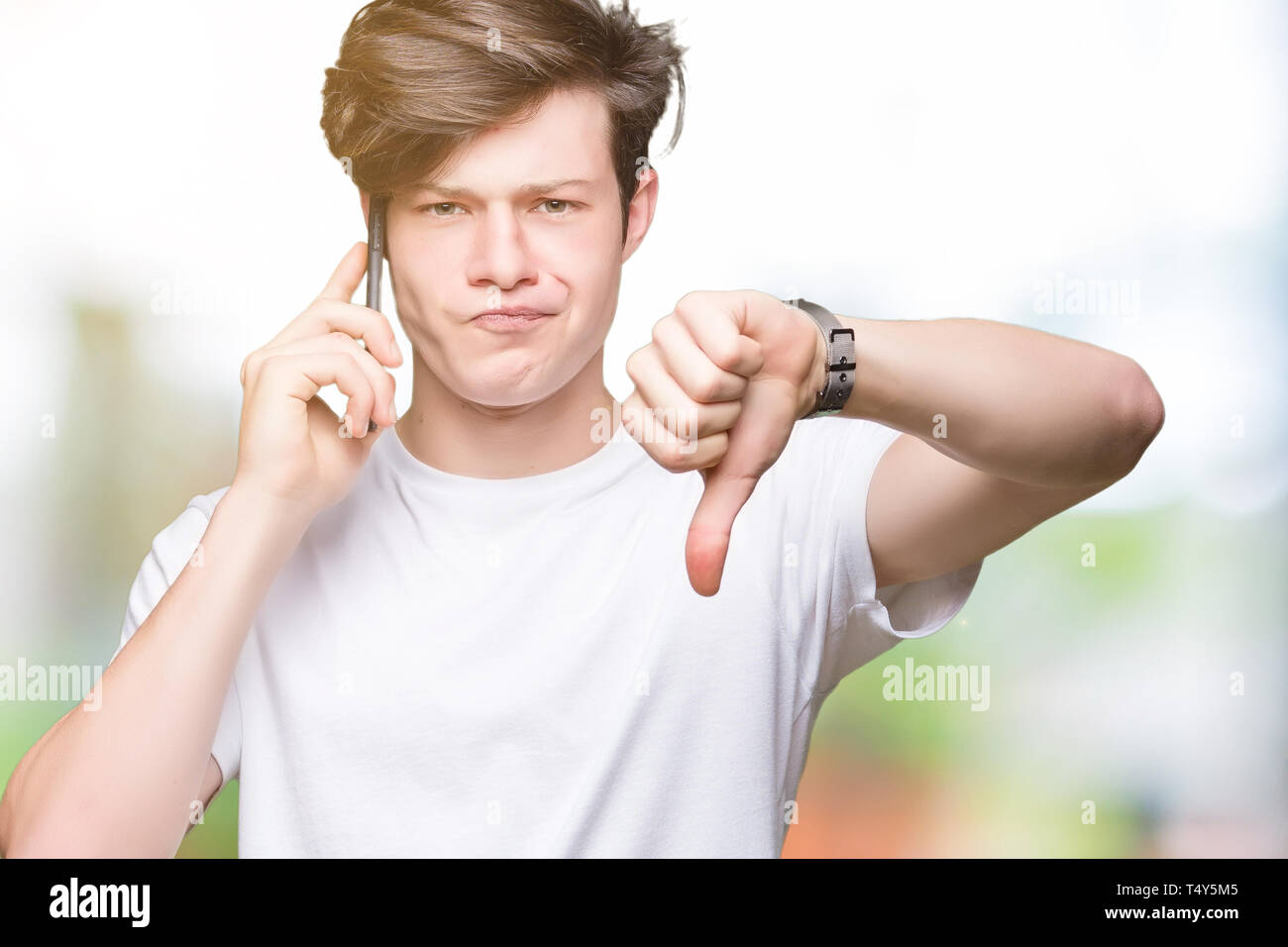 Young man talking on smartphone over isolated background with angry ...