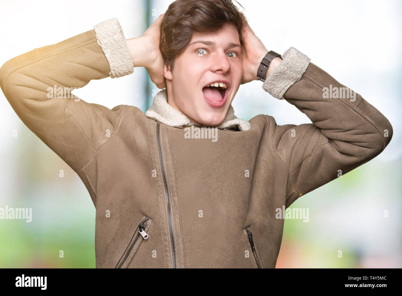 Young handsome man wearing winter coat over isolated background Crazy ...