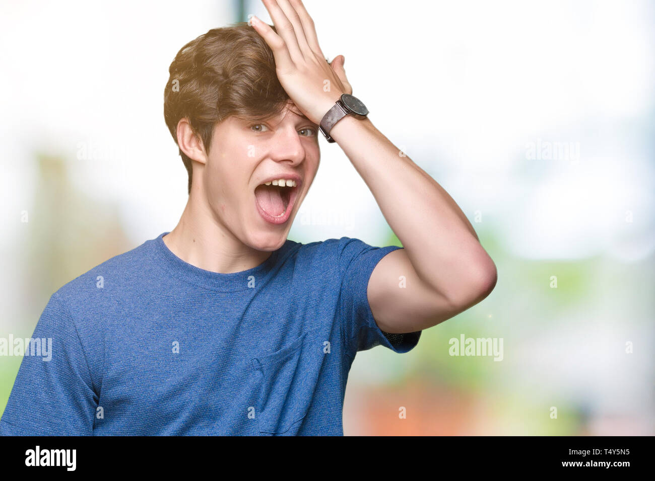 Young handsome man wearing blue t-shirt over isolated background ...
