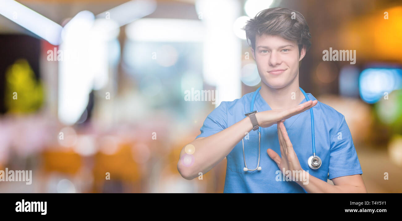 Young doctor wearing medical uniform over isolated background Doing ...