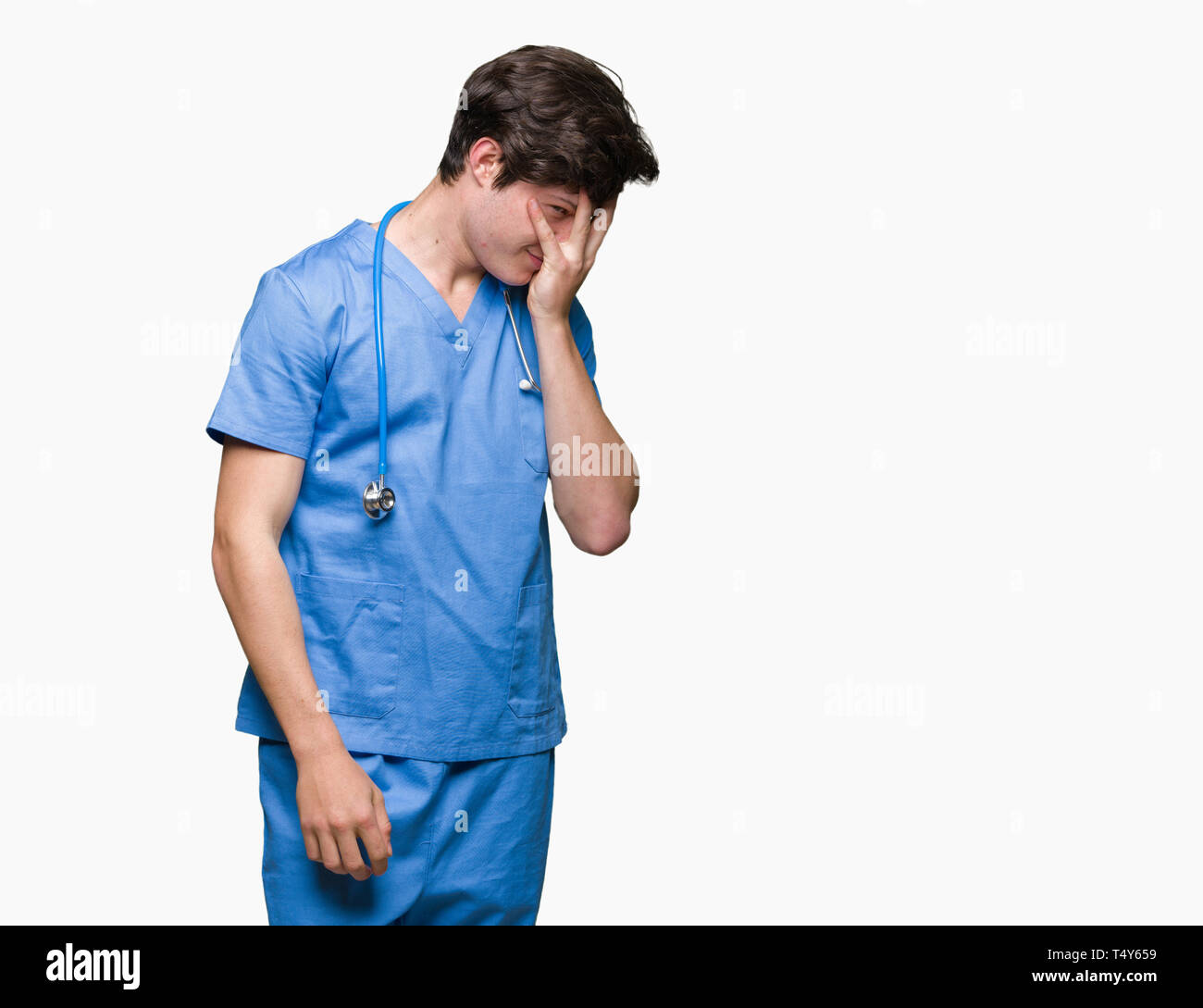 Young doctor wearing medical uniform over isolated background with sad ...